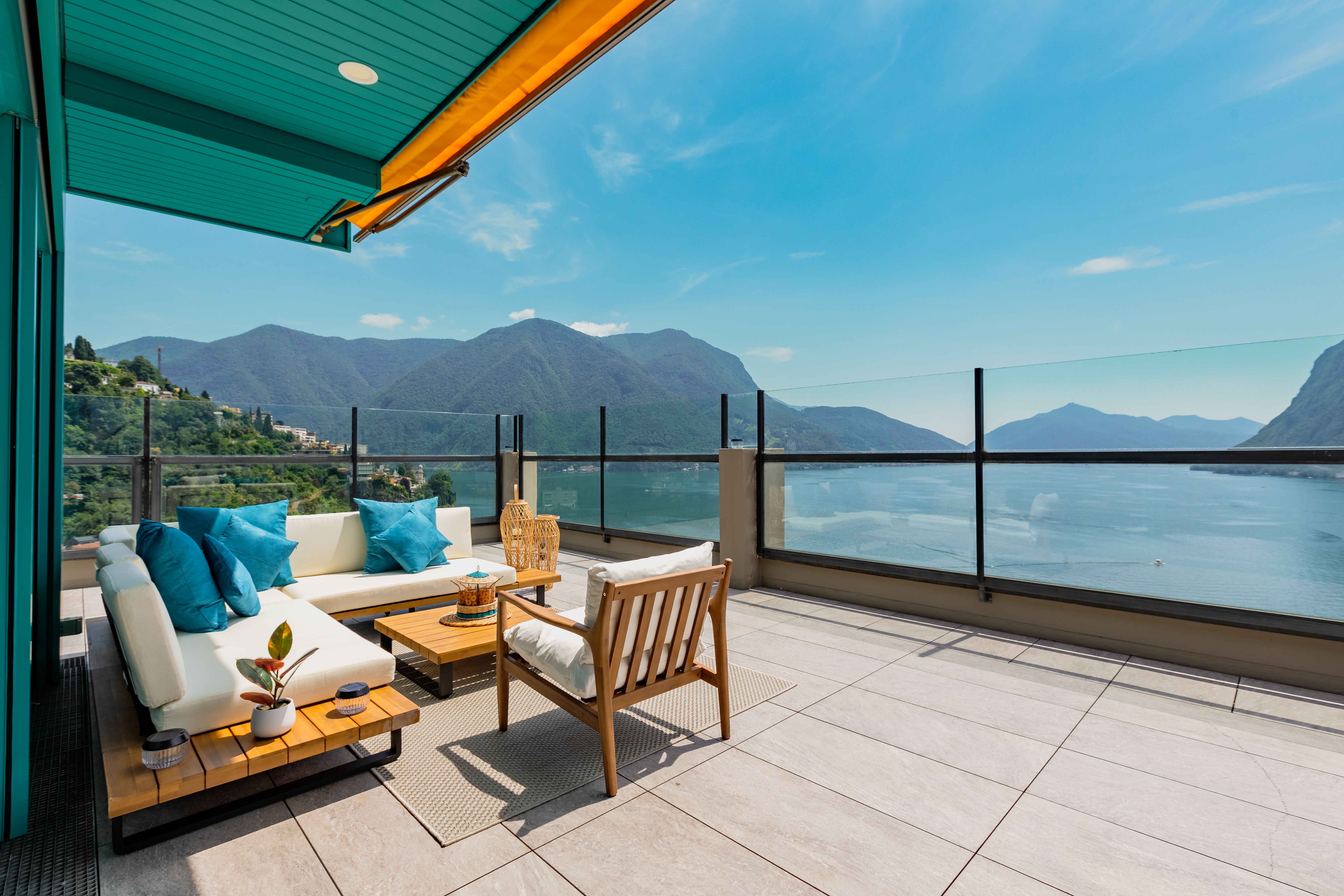 A balcony with furniture and a view of the lake · Free Stock Photo