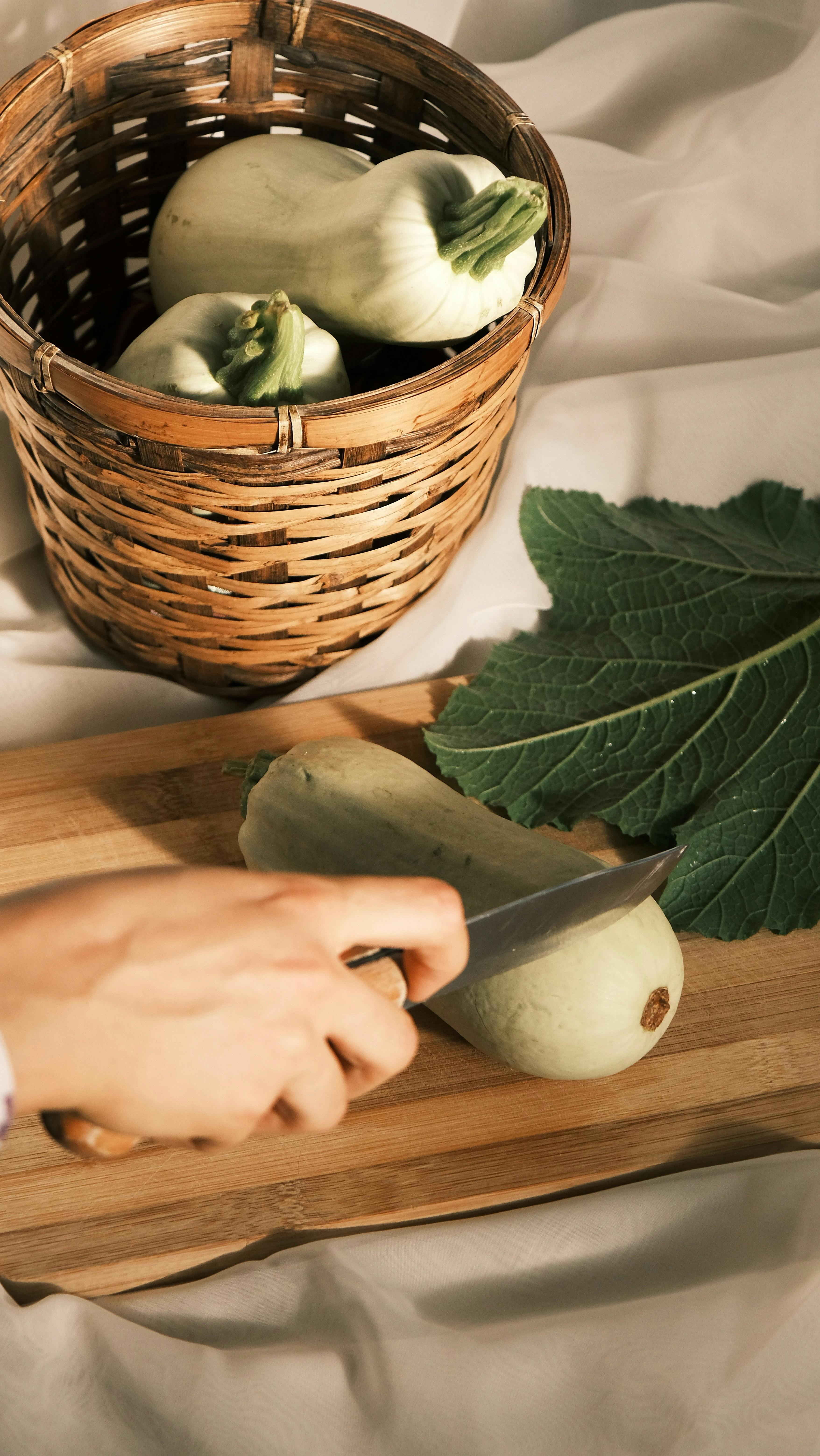 Hand of a Person Cutting a White Zucchini · Free Stock Photo