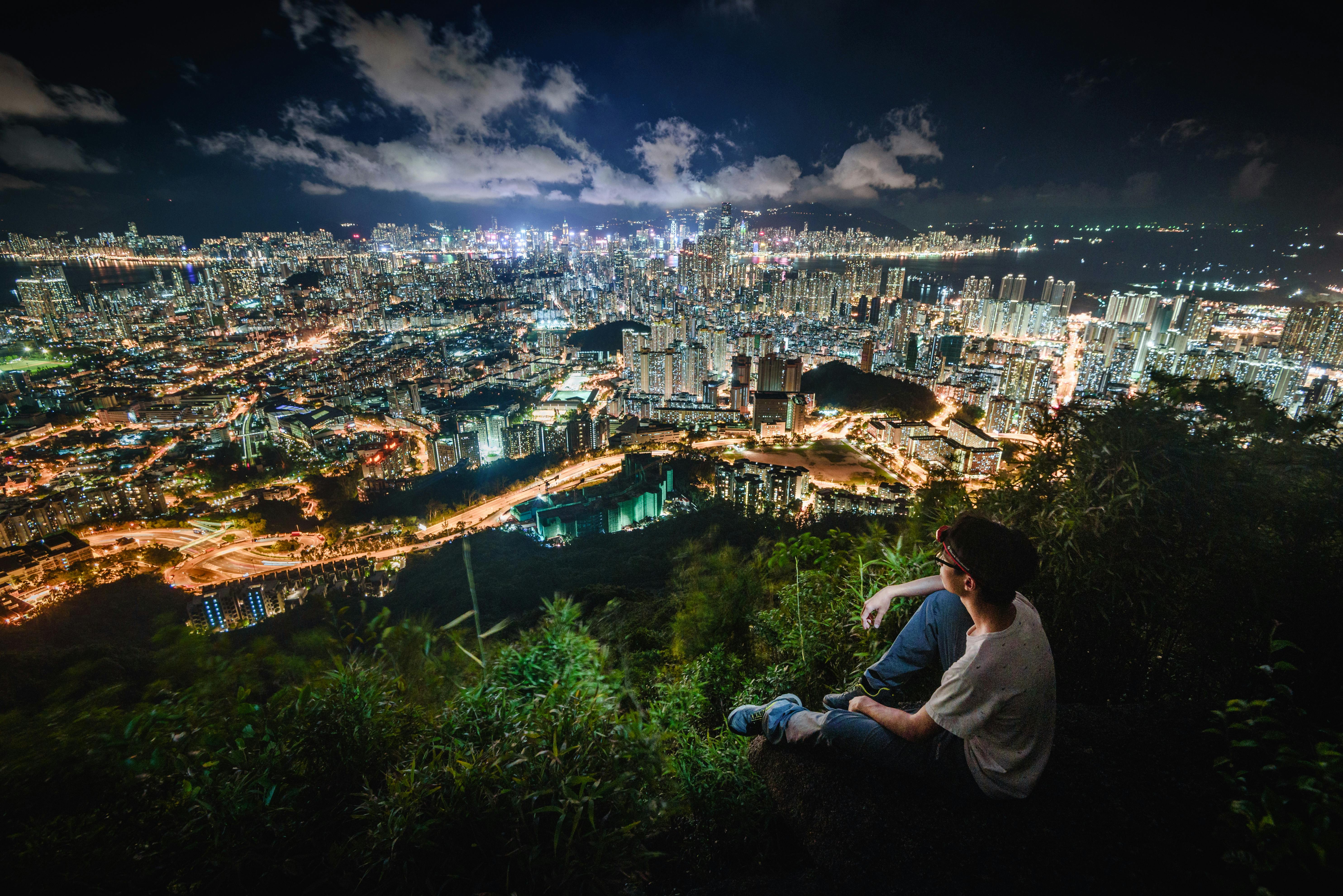 Photo of Man Sitting While Overlooking a City · Free Stock Photo