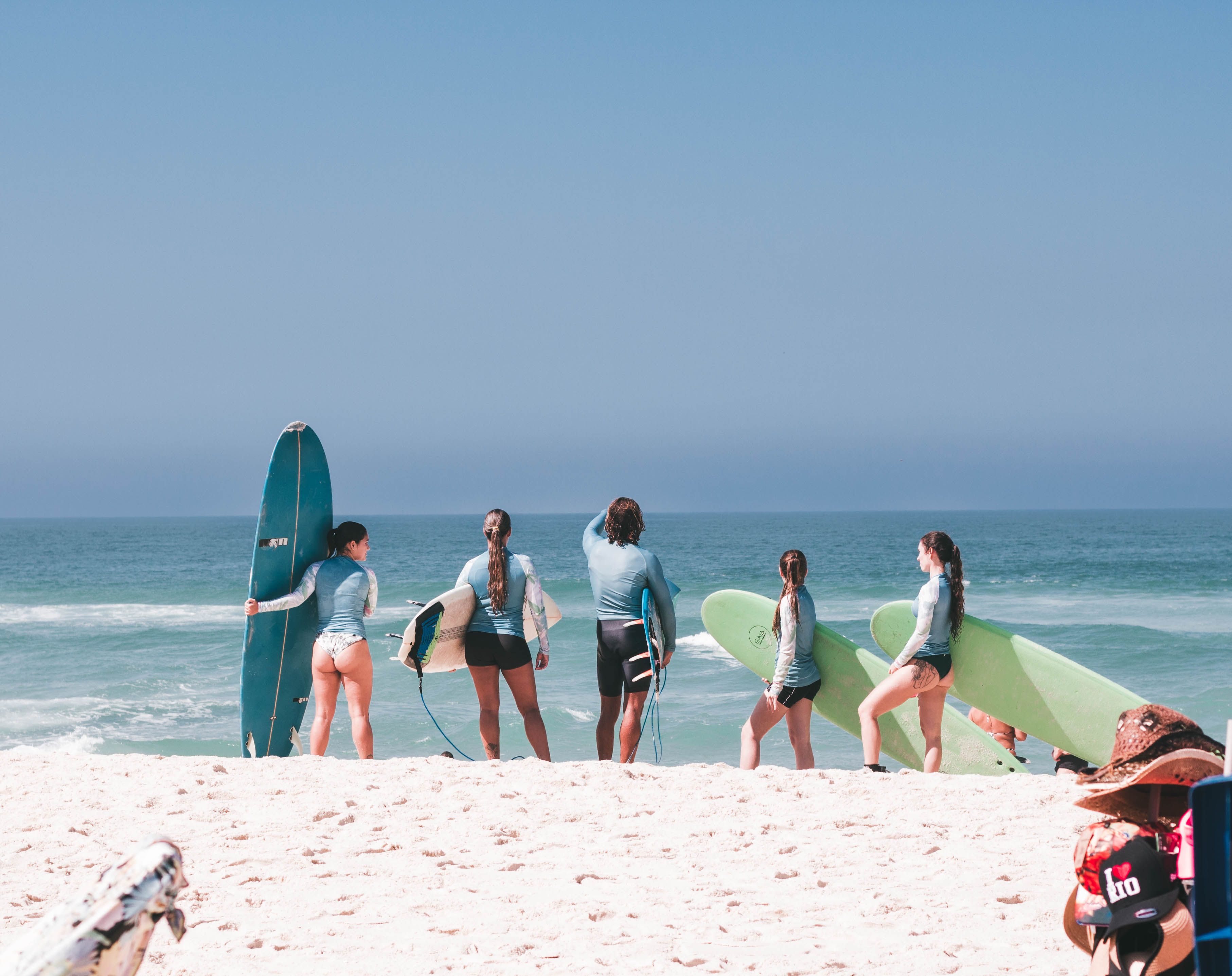 Back View of Surfers on Sea Shore · Free Stock Photo