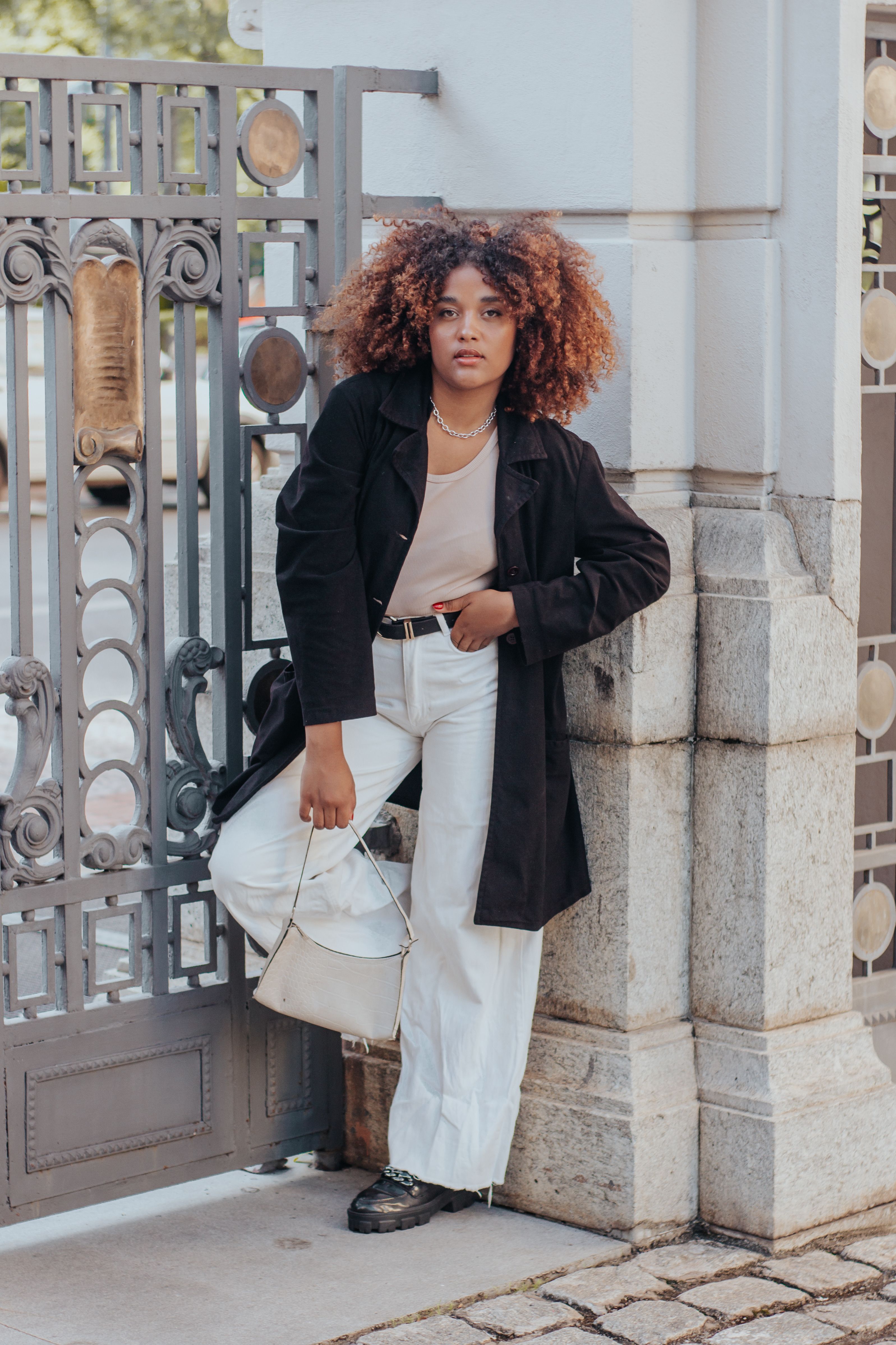 A Fashionable Woman Standing on a Sidewalk · Free Stock Photo