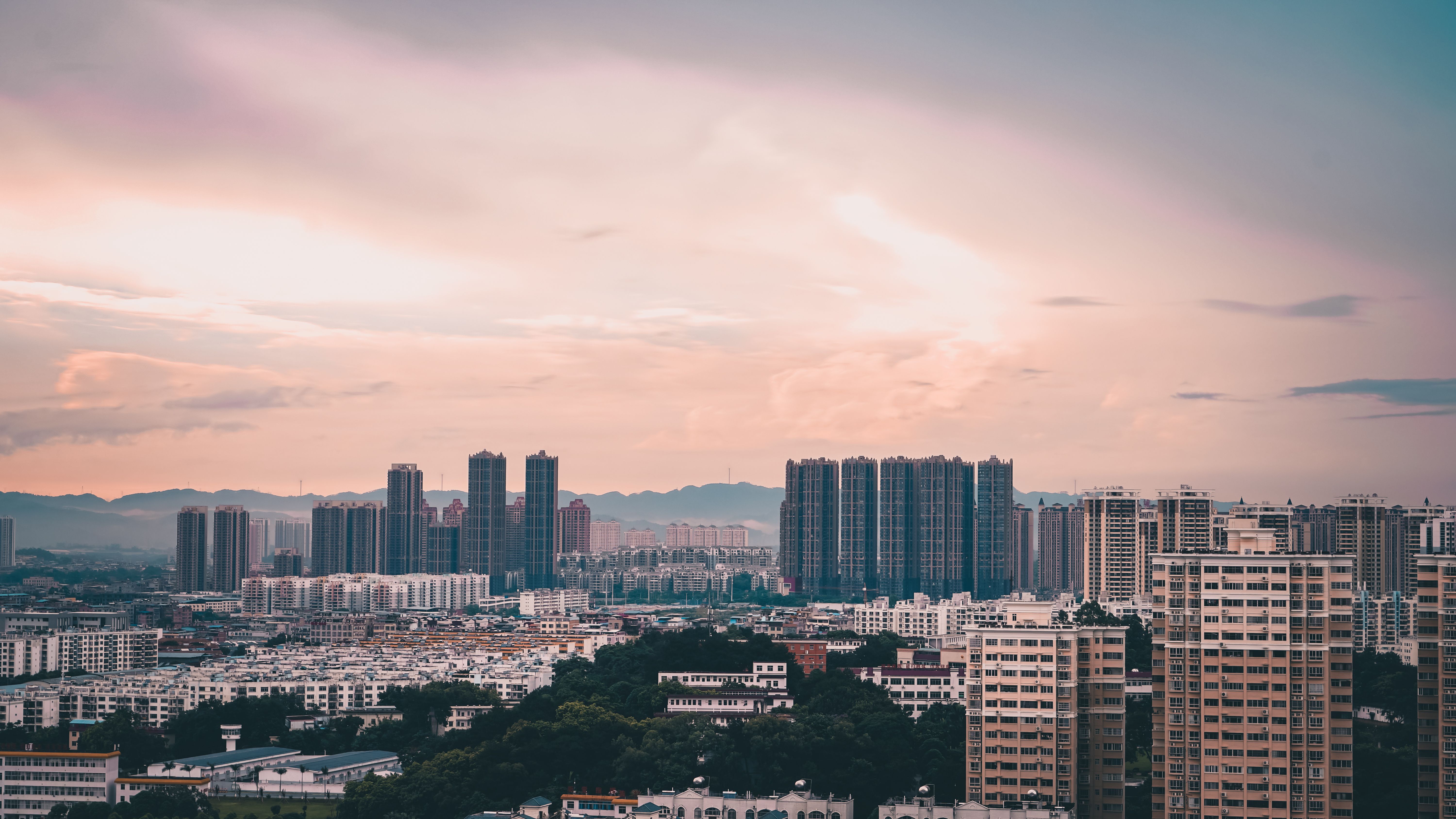 A city skyline with buildings and trees in the distance · Free Stock Photo