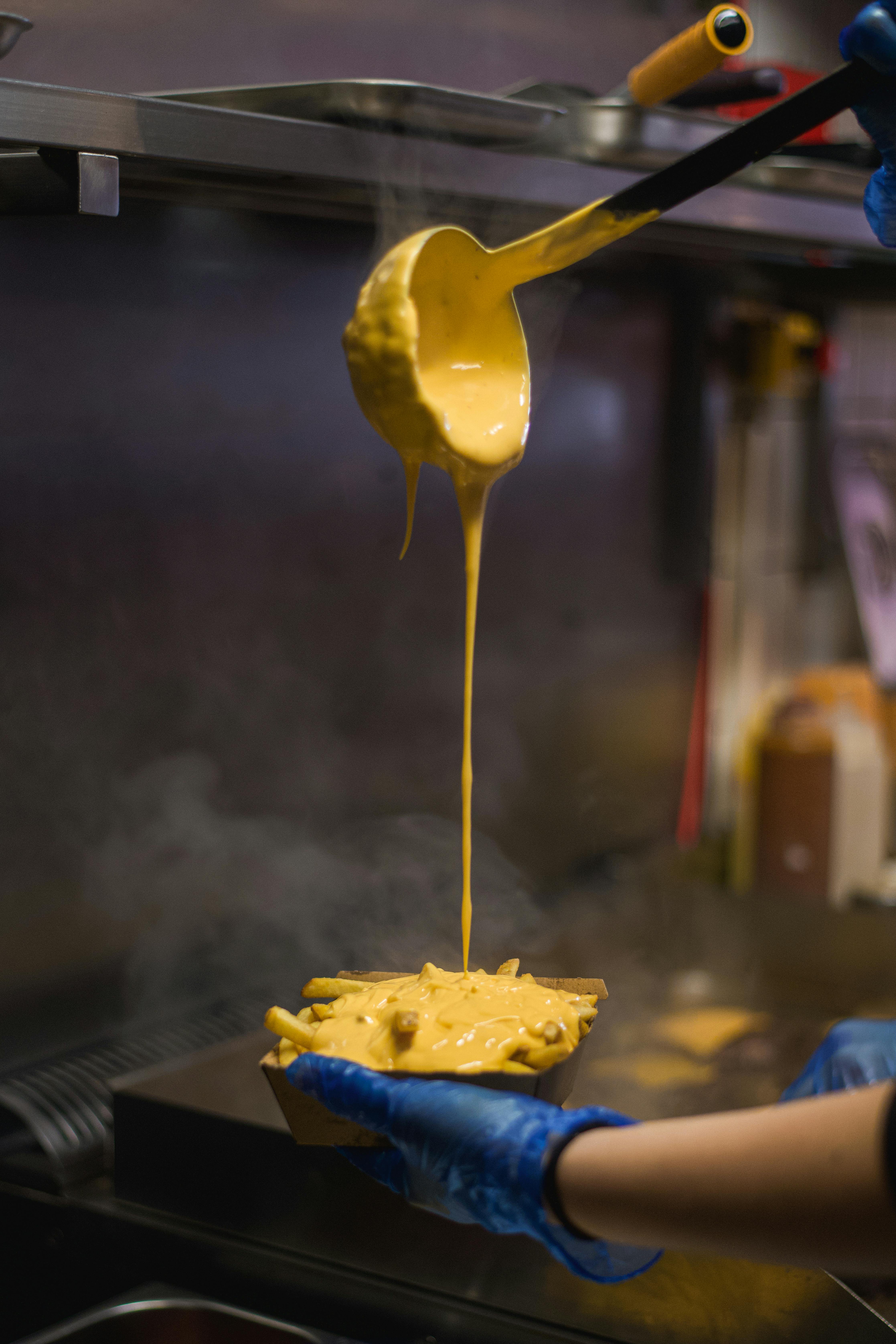 Pouring Melted Cheese to Fries · Free Stock Photo