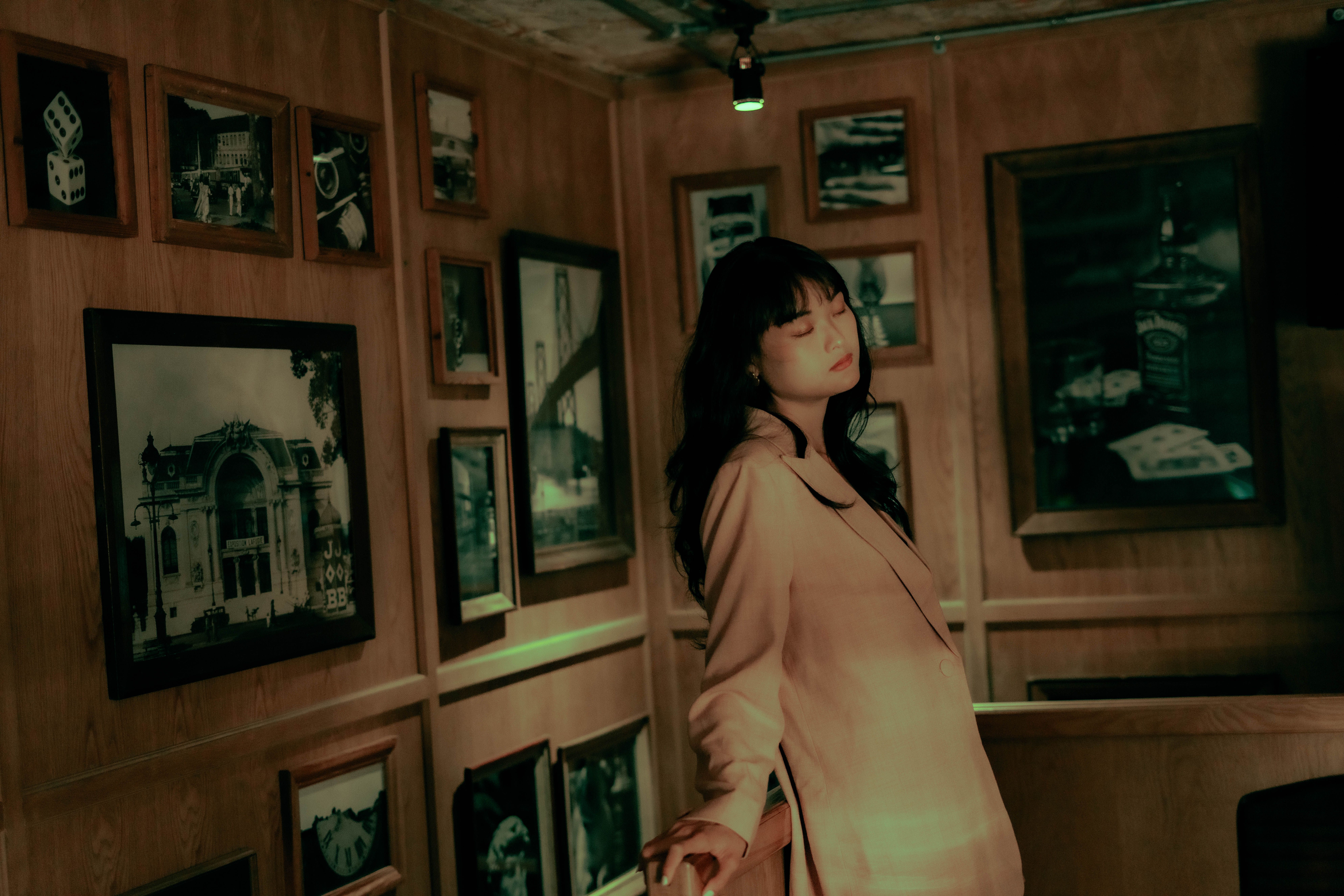 A woman standing in front of a wall of pictures · Free Stock Photo