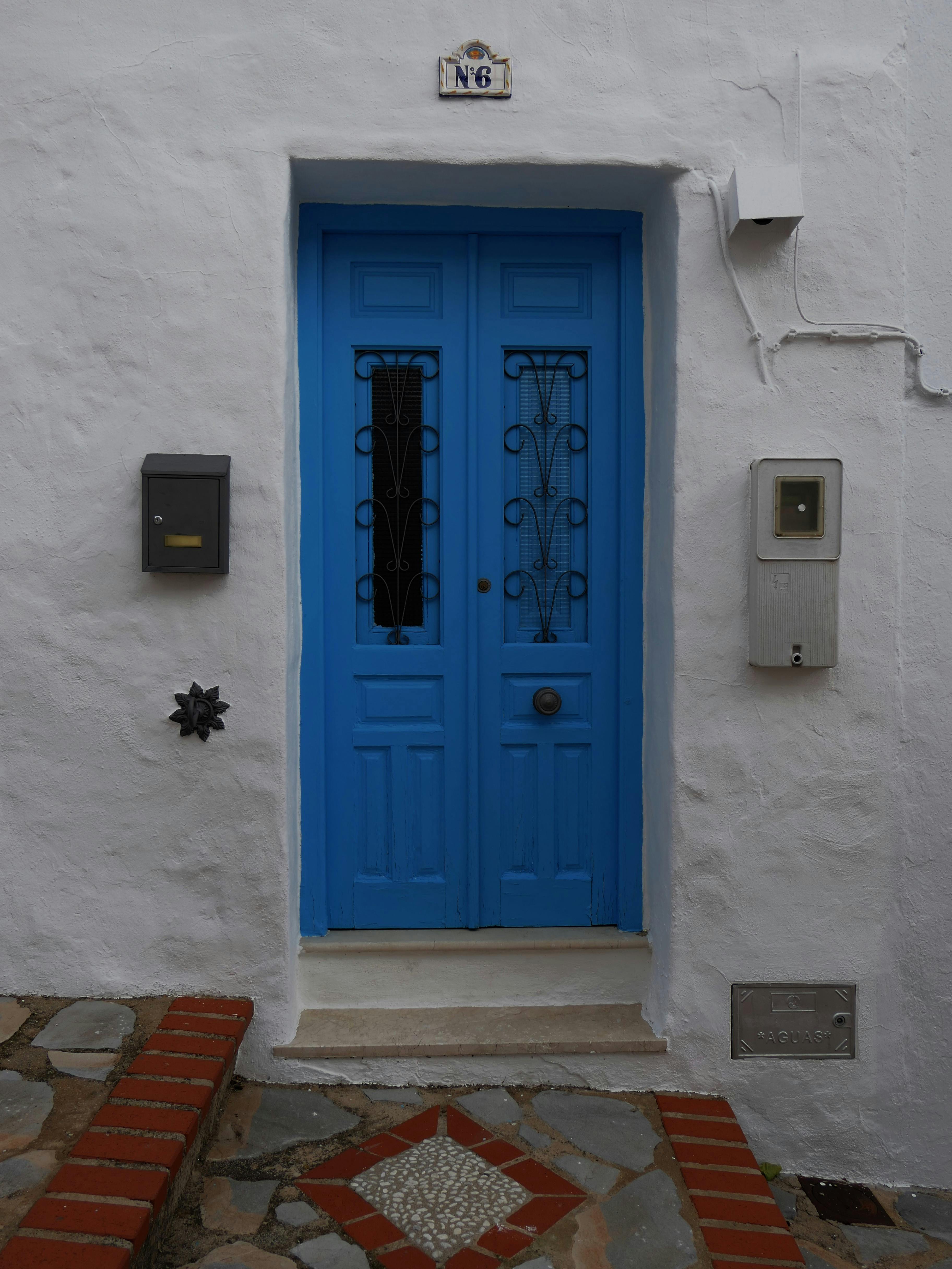 Person Standing in Between White Buildings · Free Stock Photo