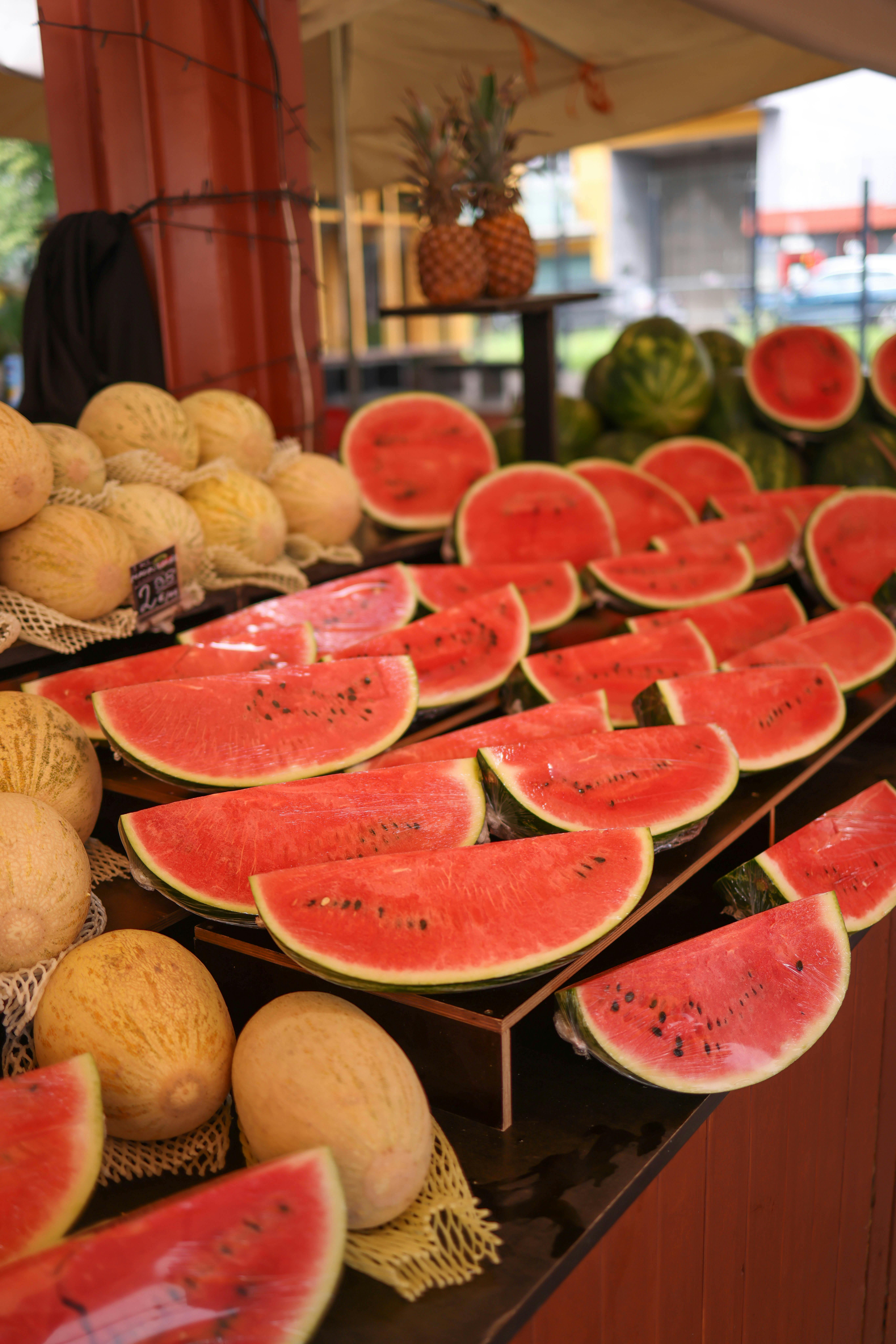 A display of watermelons and pineapples · Free Stock Photo