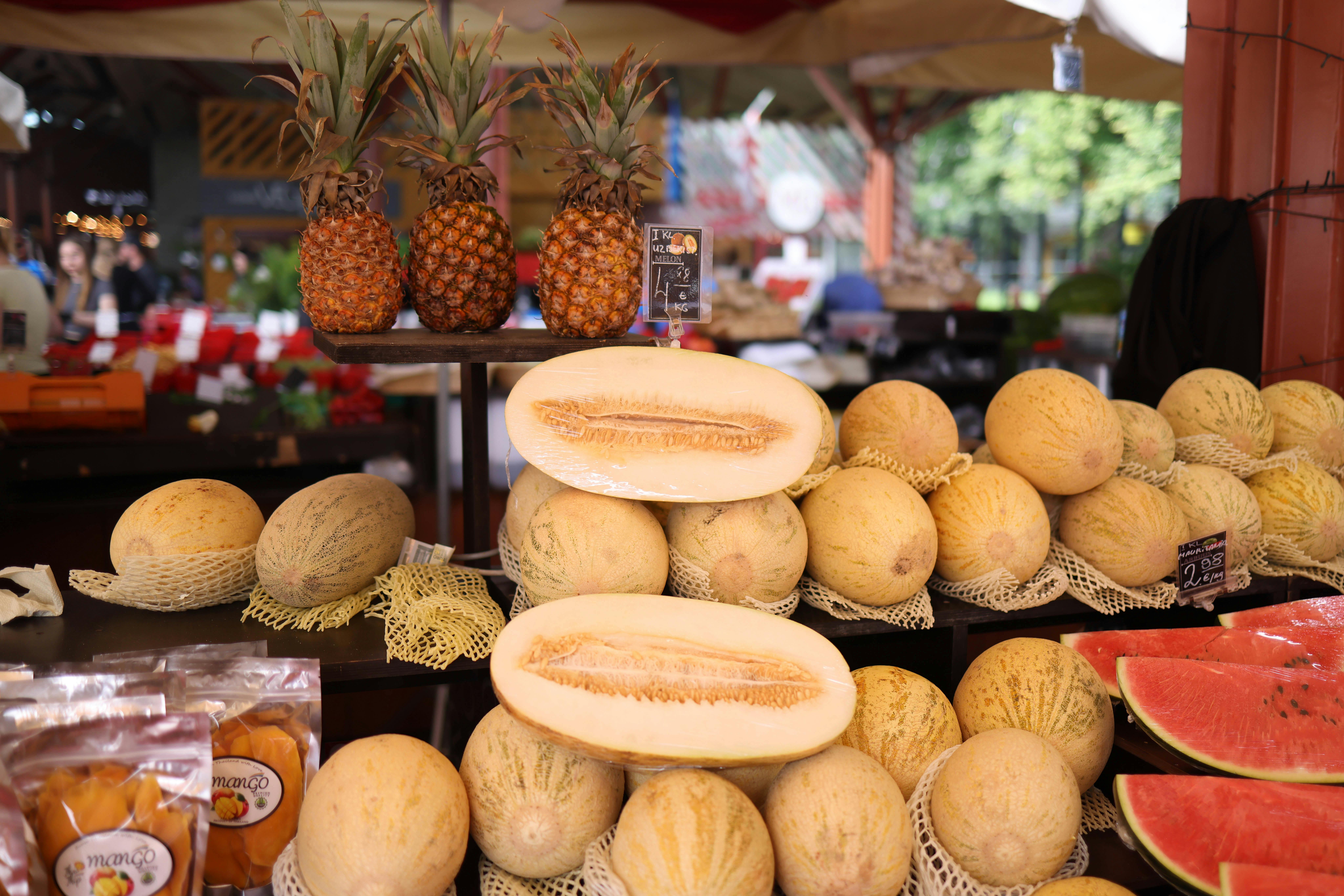 A display of melons and pineapples at a market · Free Stock Photo
