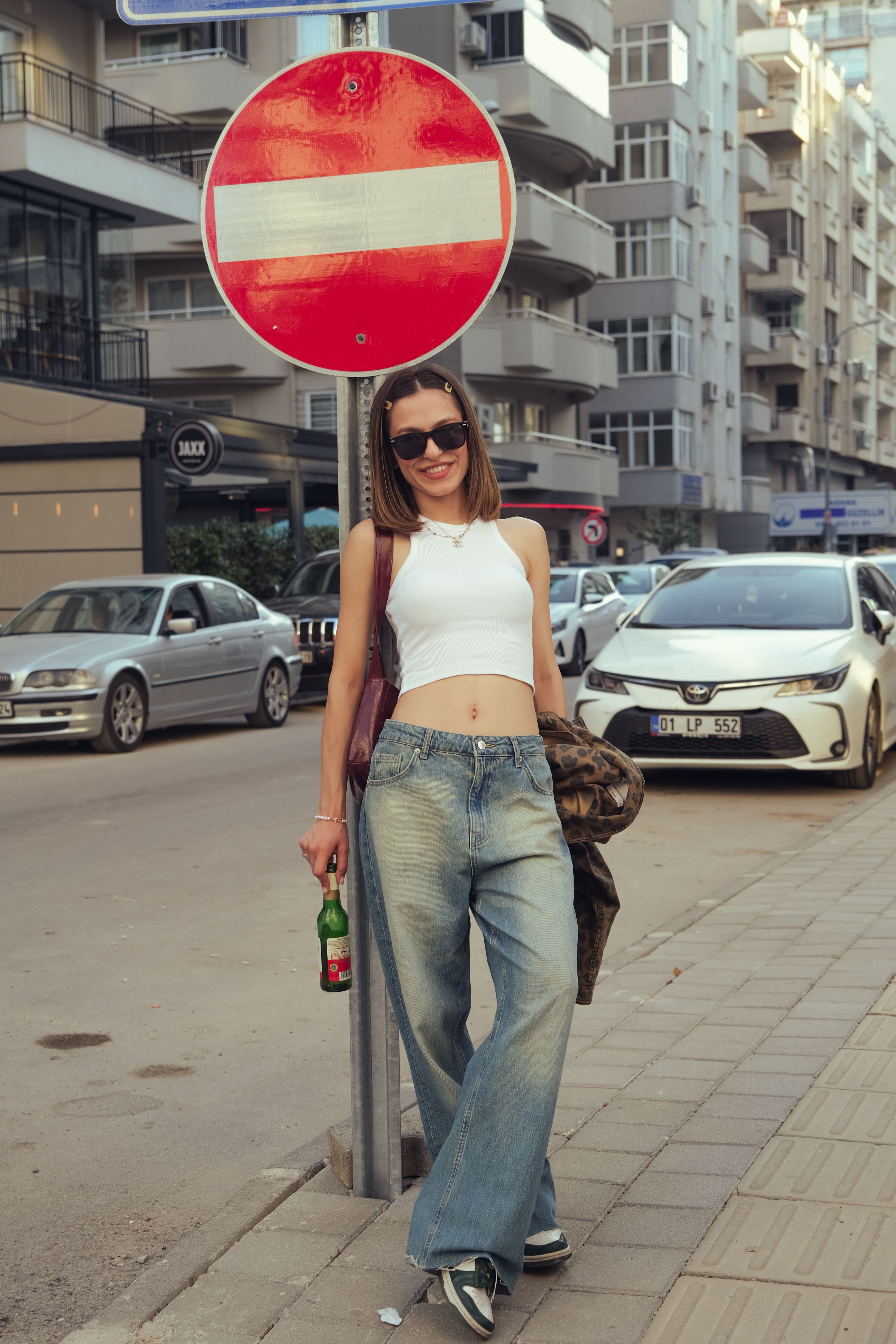 A Woman Posing by a Road Sign · Free Stock Photo