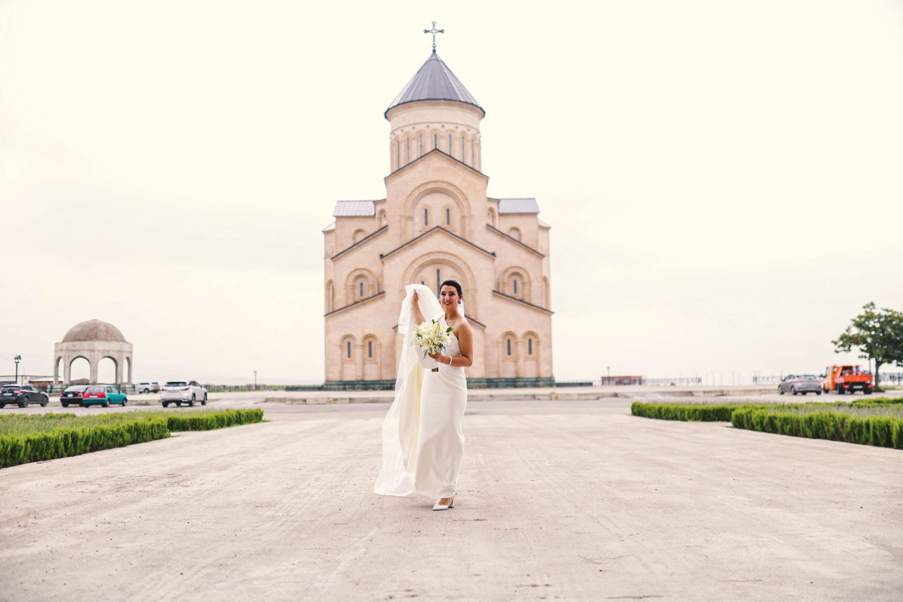 Bride Standing in Wedding Dress with Church behind · Free Stock Photo