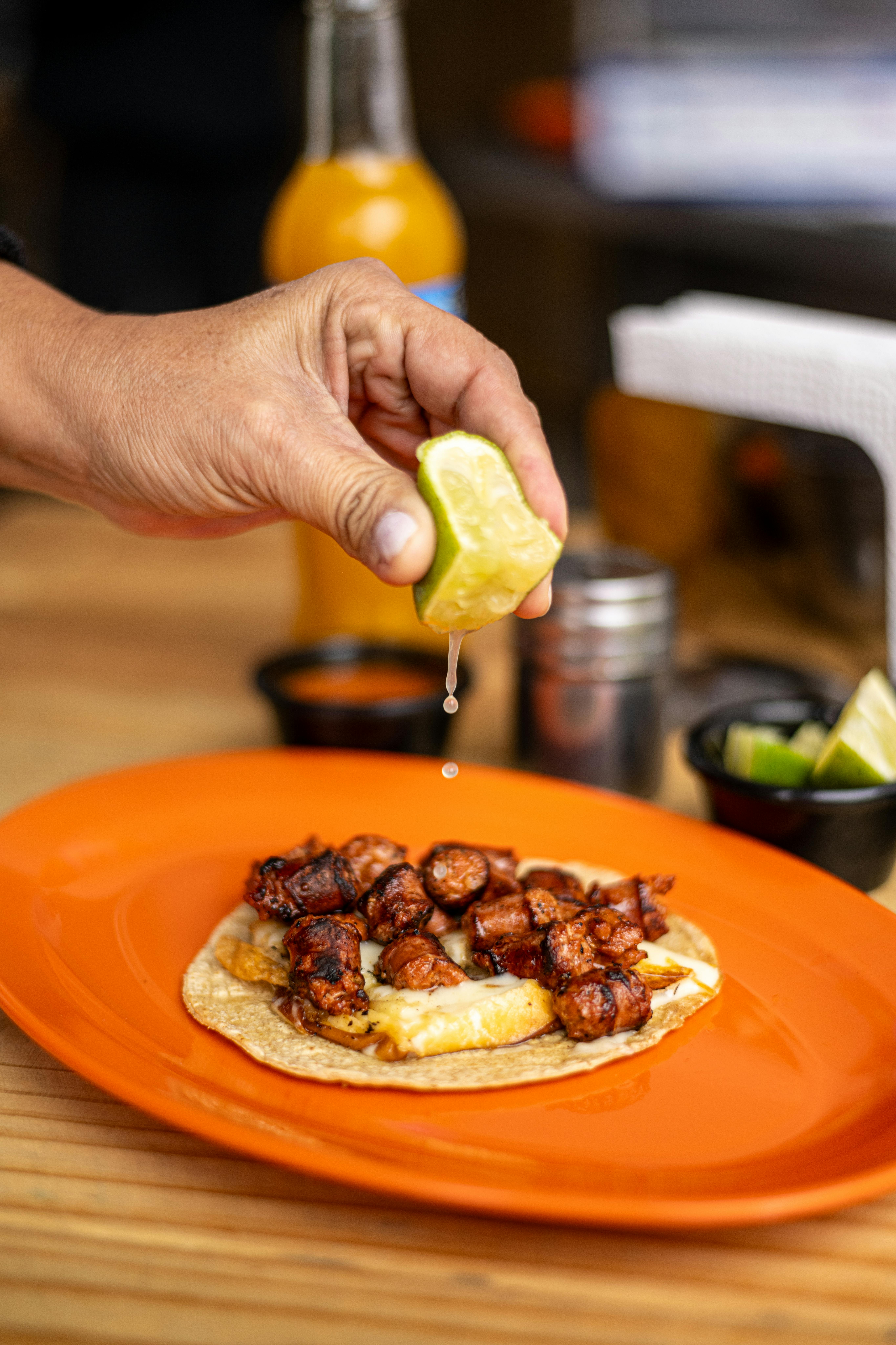 Hand Squeezing Lime over Meal · Free Stock Photo
