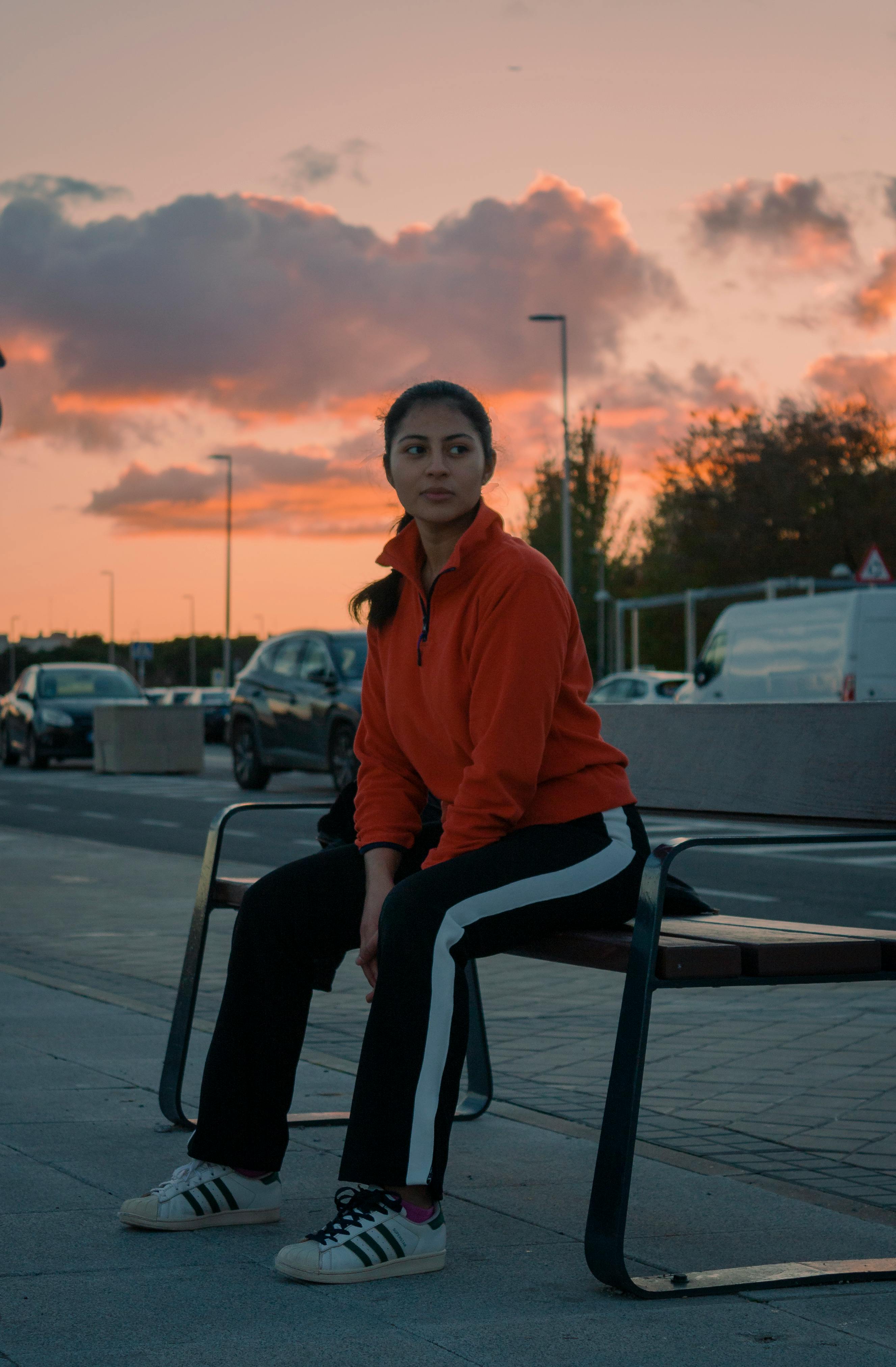 Woman Wearing Red Jacket on a Street During Sunset · Free Stock Photo