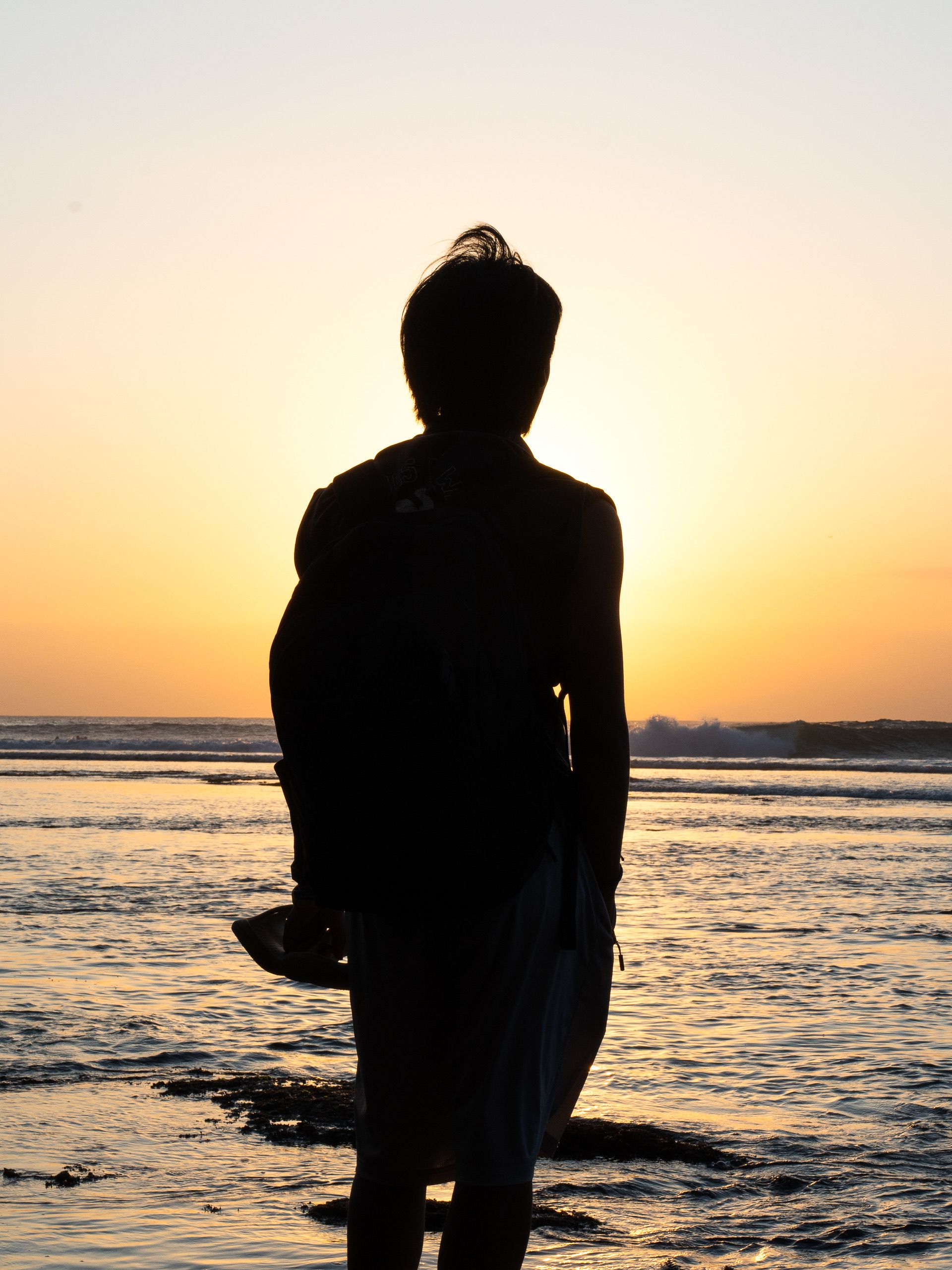 Silhouette of Person Standing on Sea Shore at Sunrise · Free Stock Photo