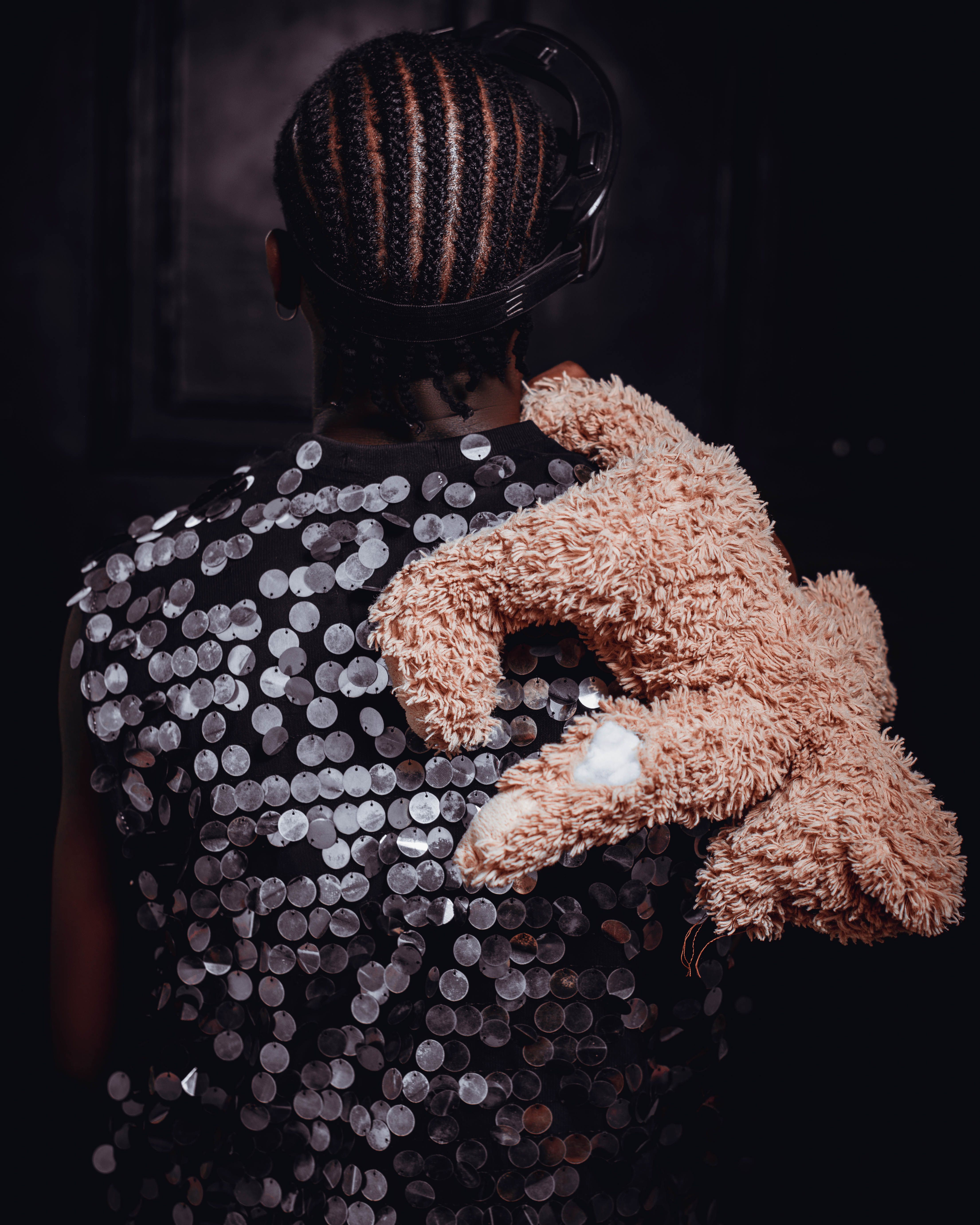 Person Standing on Black Background Holding Plush Toy over their Back ...