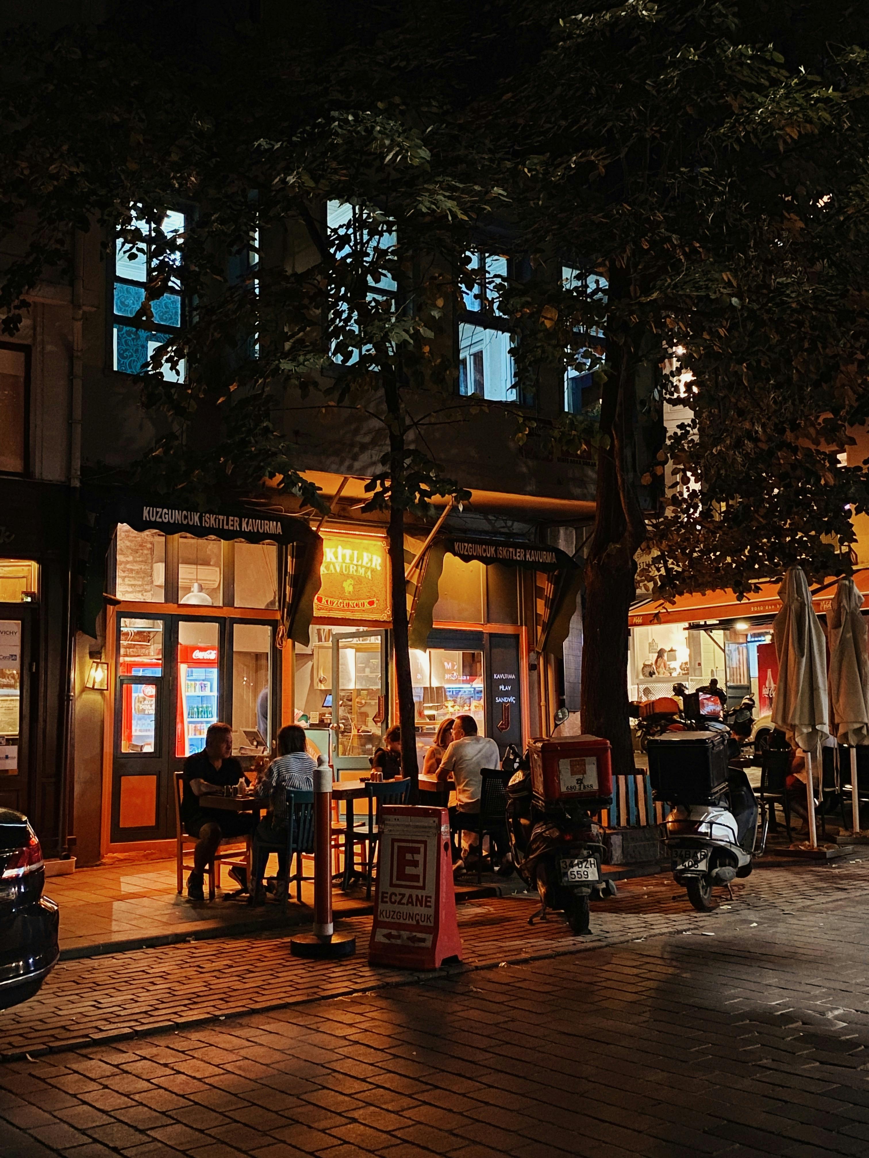 People Dining Outside of a Restaurant in a City at Night · Free Stock Photo