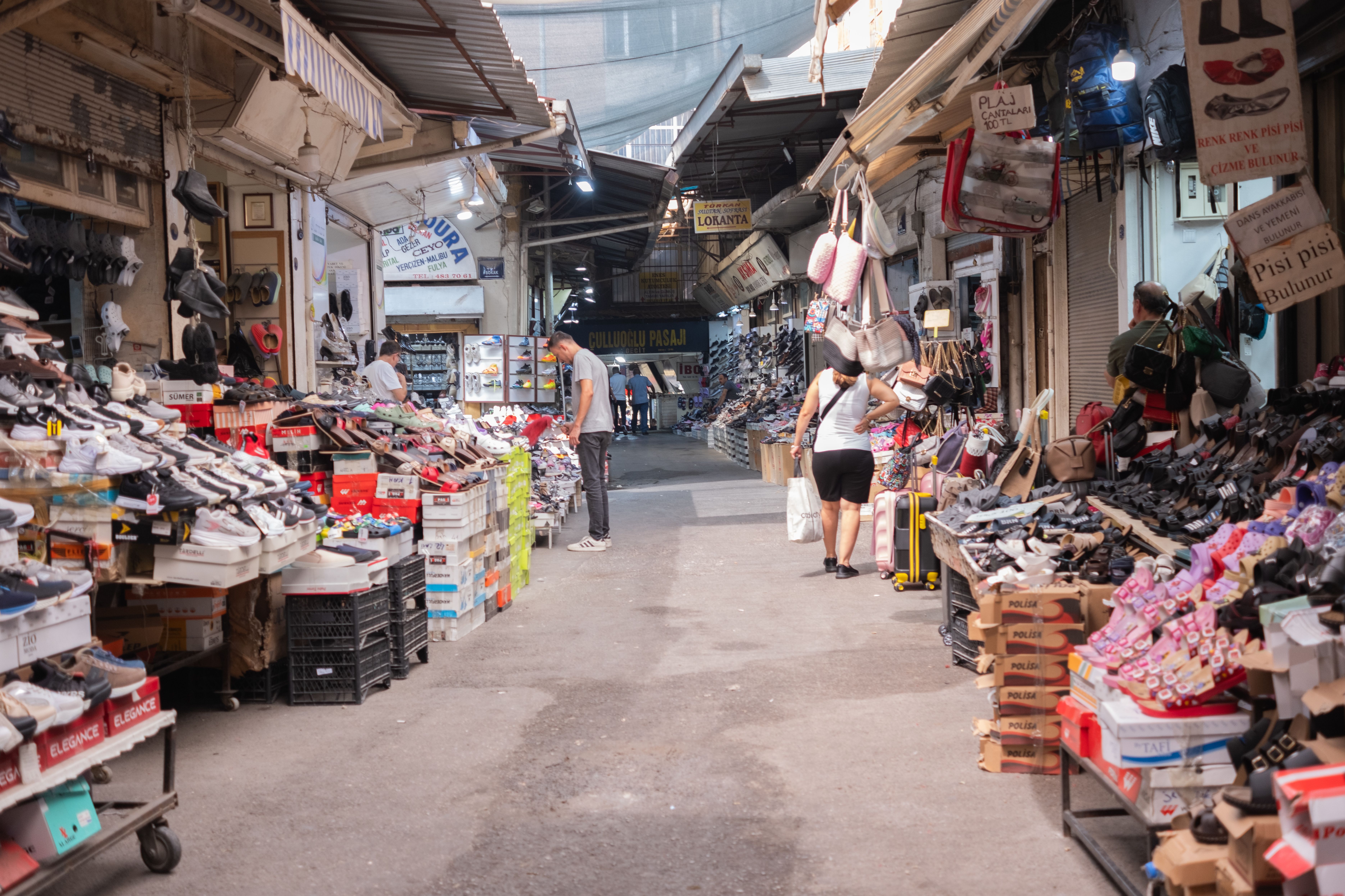 A street with many shoes and other items for sale · Free Stock Photo