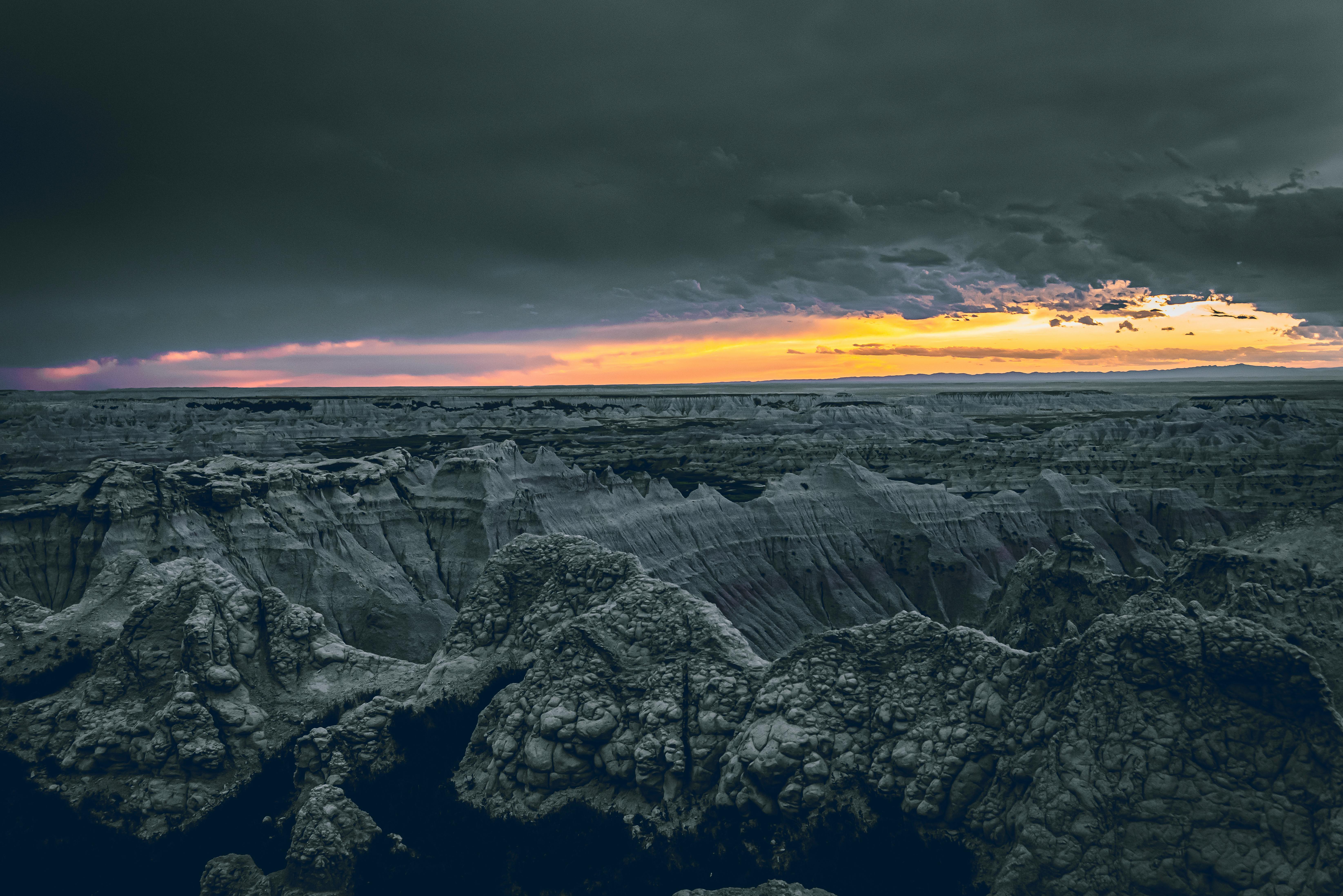Endless mountain terrain under overcast sunset sky · Free Stock Photo