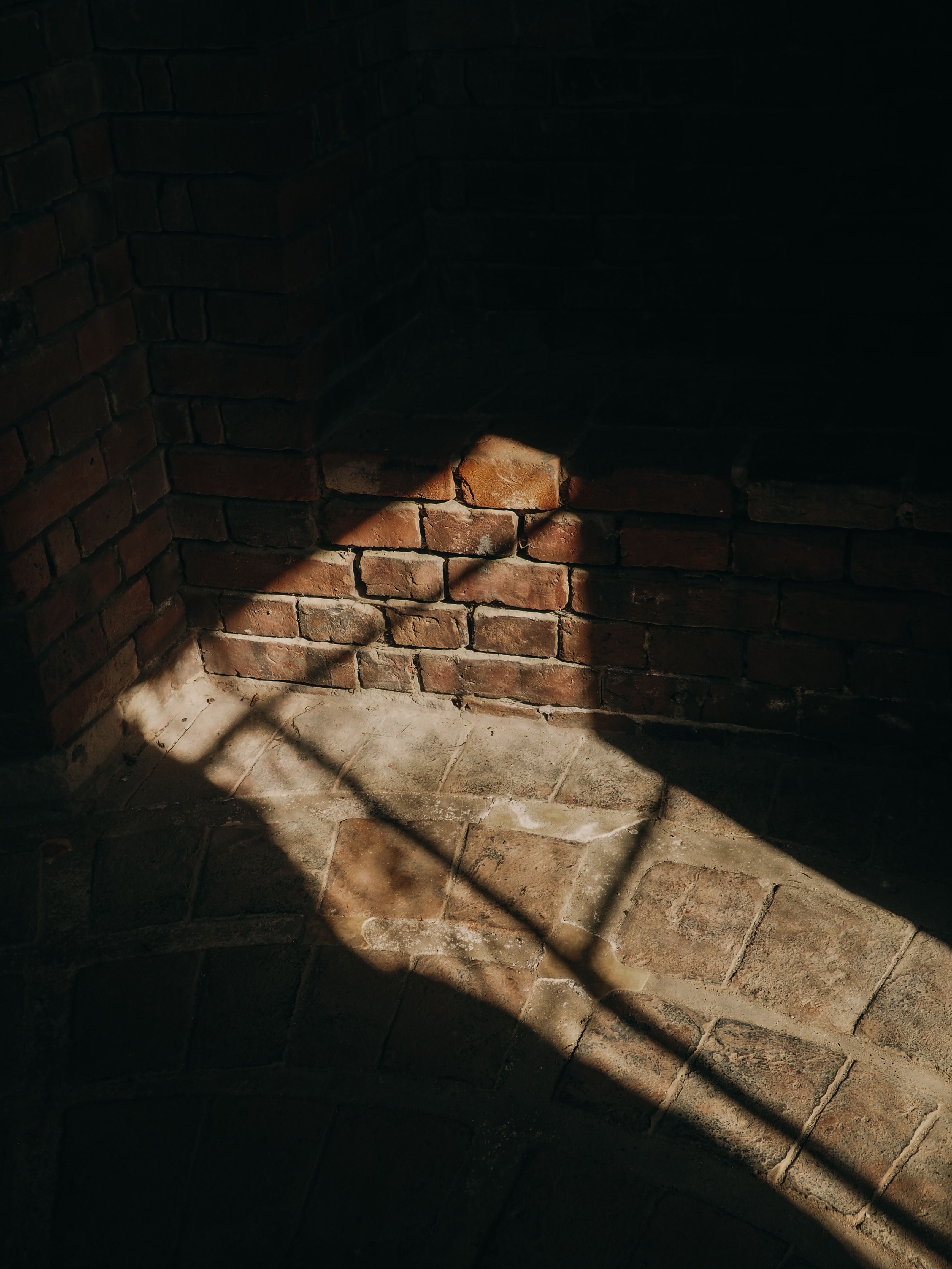Sunlight Illuminating a Part of a Brick Wall and Floor · Free Stock Photo