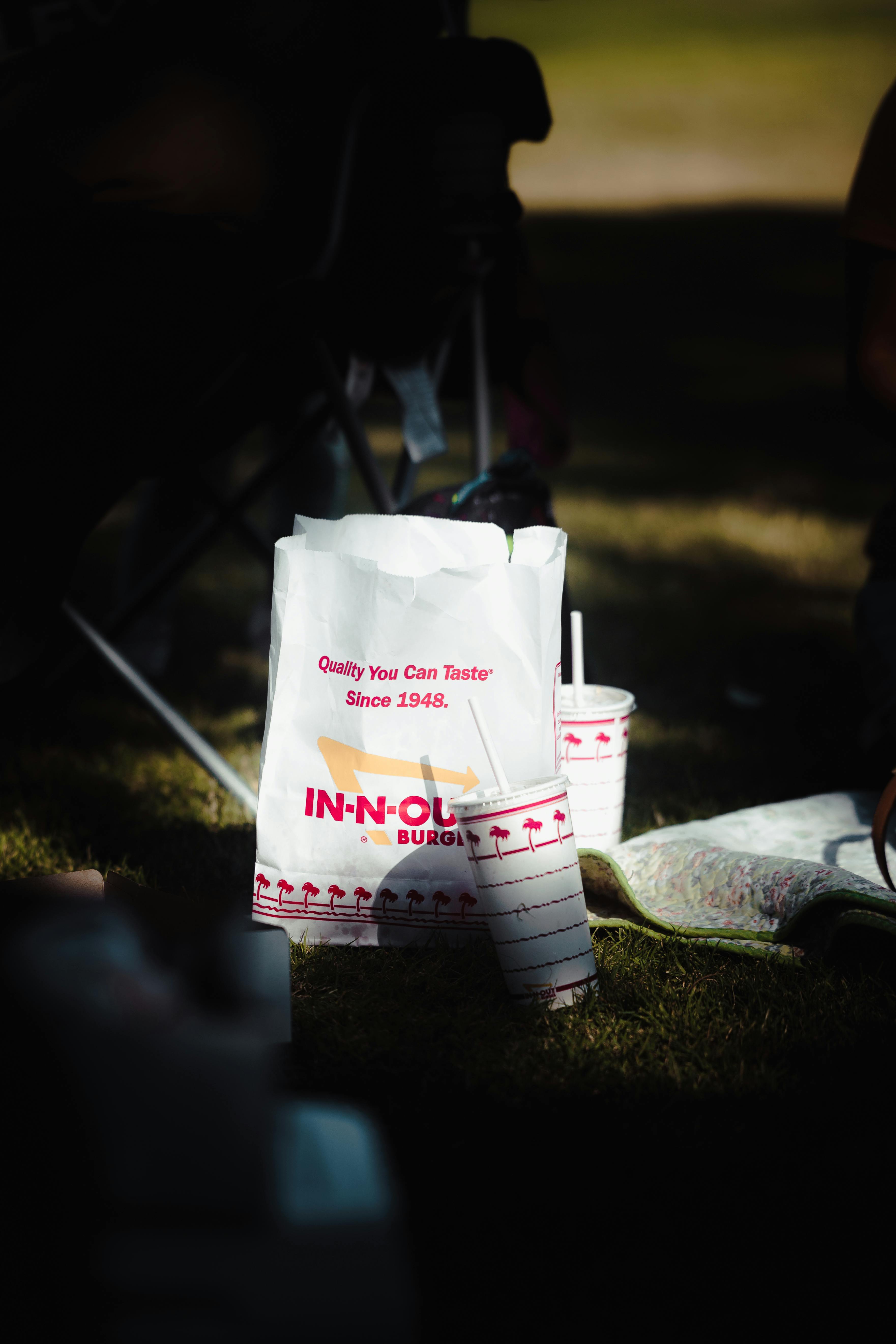 A bag of fast food sitting on the grass · Free Stock Photo