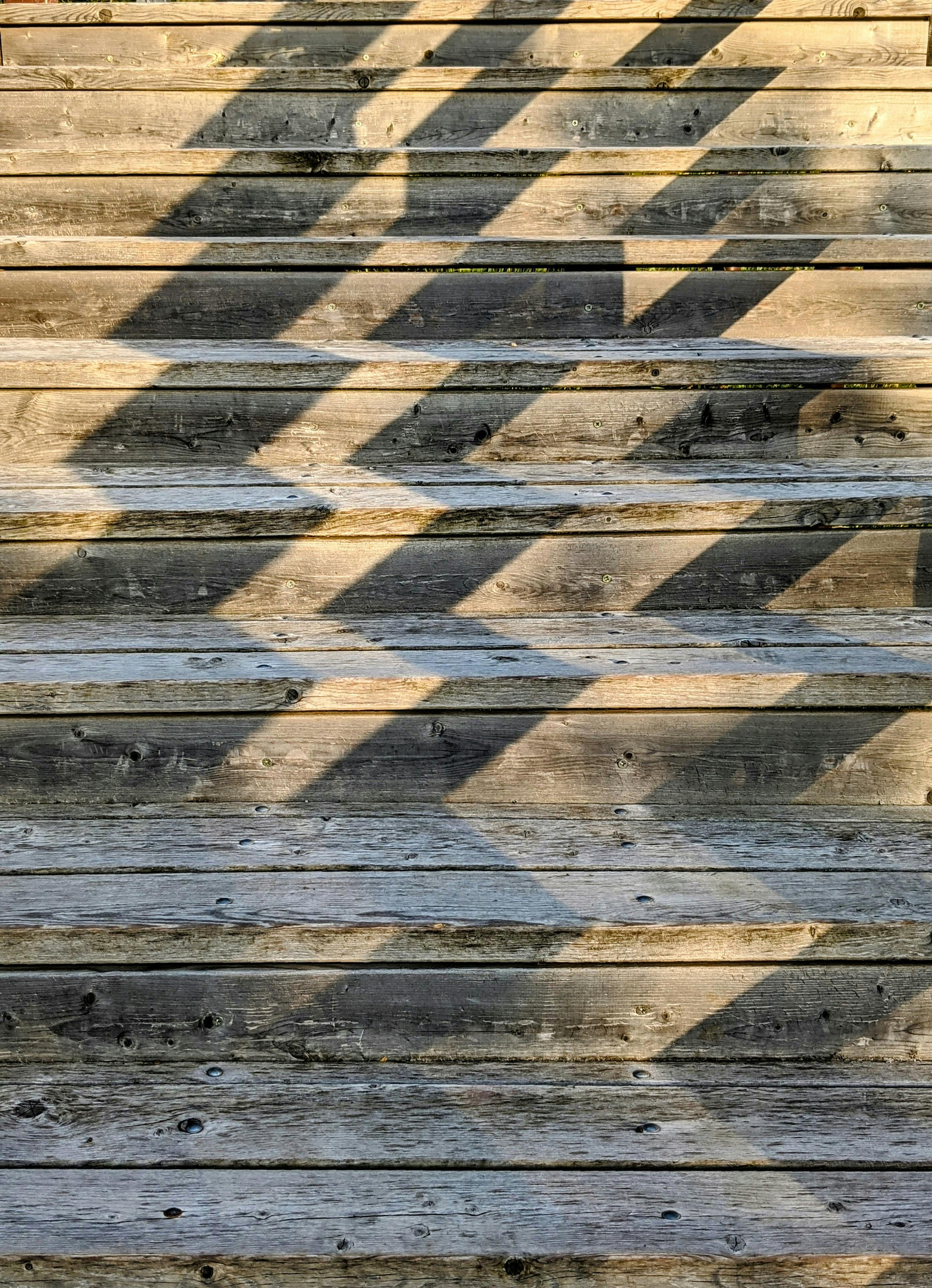 A wooden staircase with shadows of the stairs · Free Stock Photo