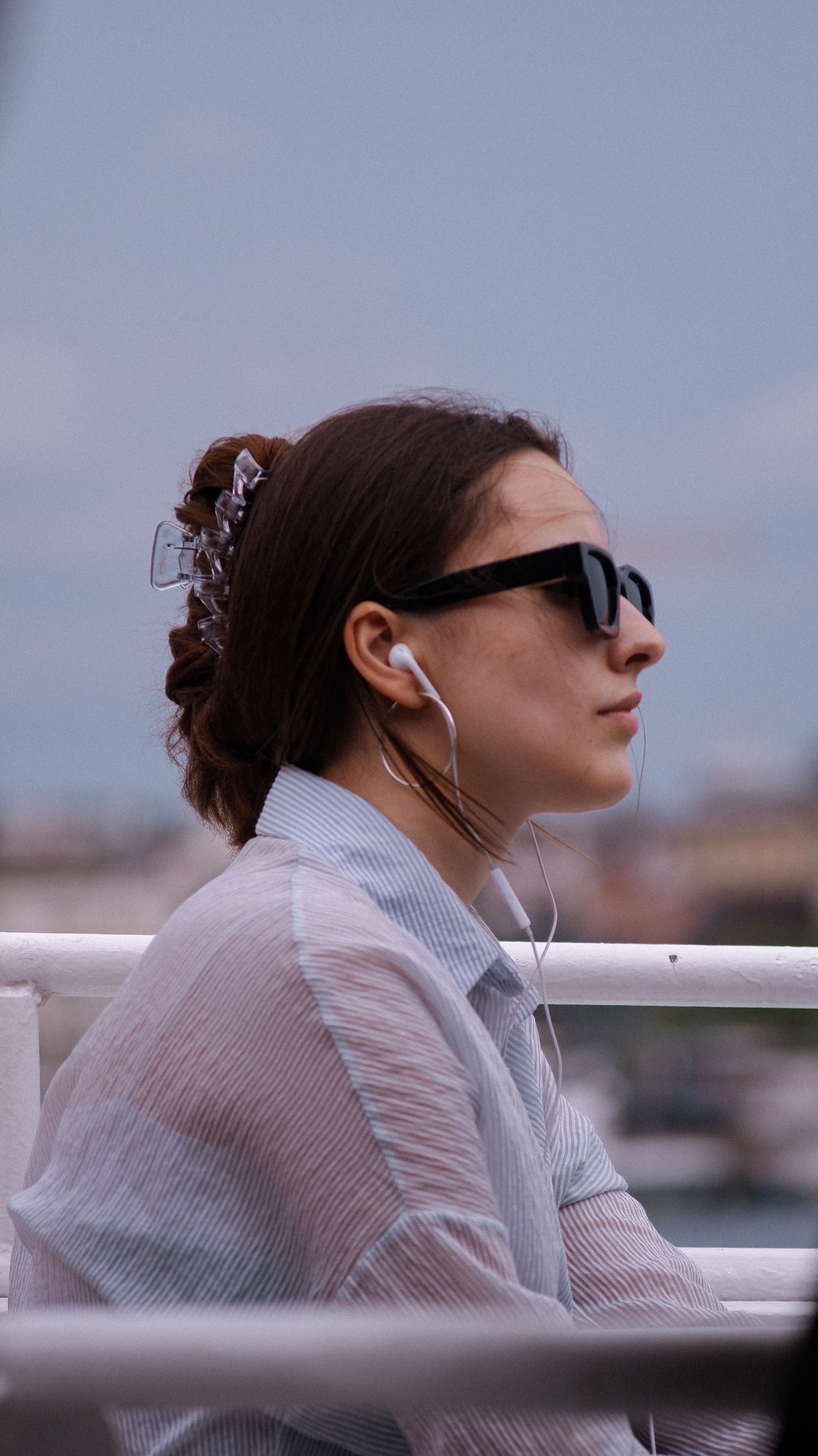 Profile View of a Woman Wearing Sunglasses and Earbuds · Free Stock Photo