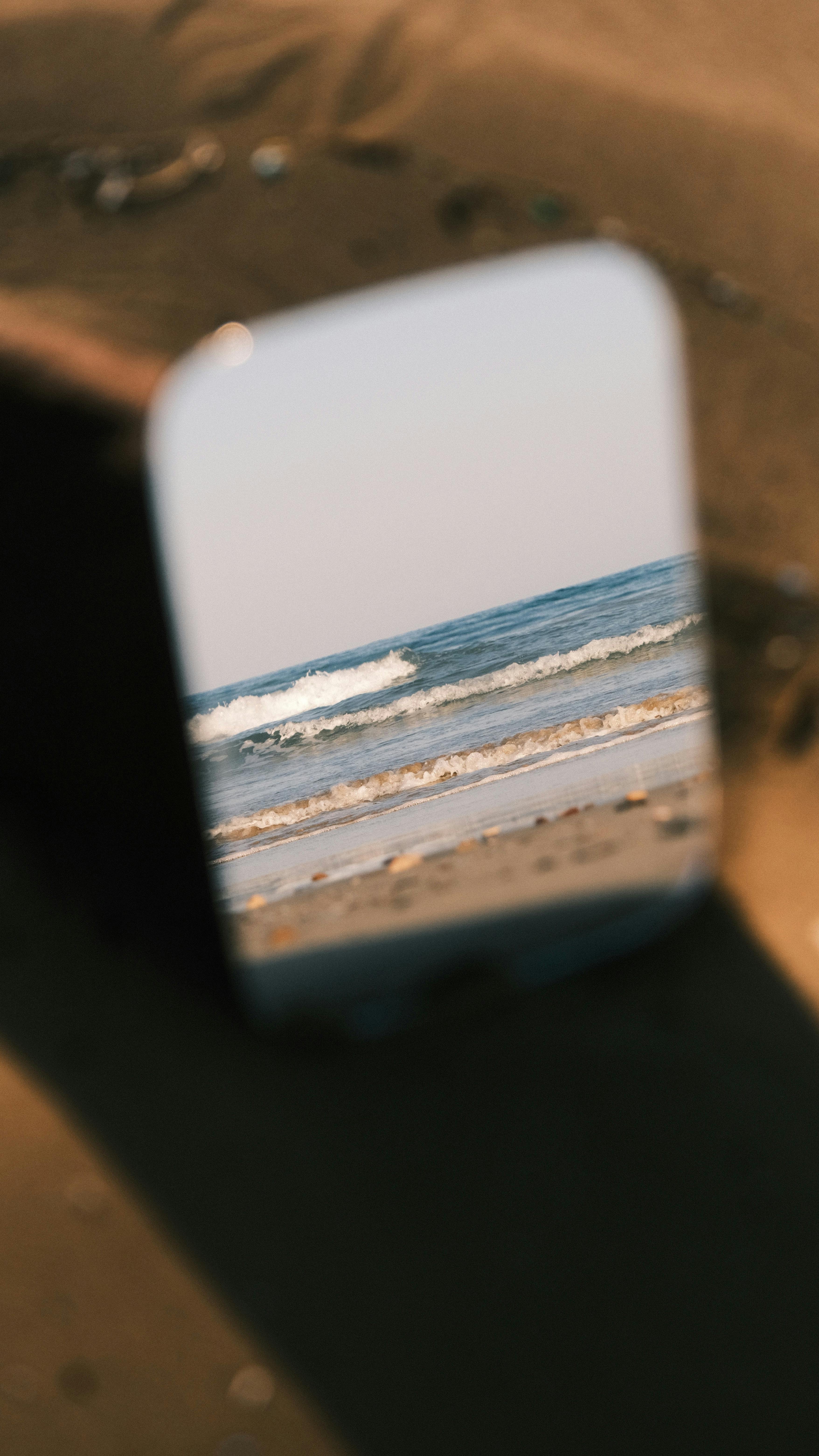 A mirror reflecting the ocean and beach · Free Stock Photo