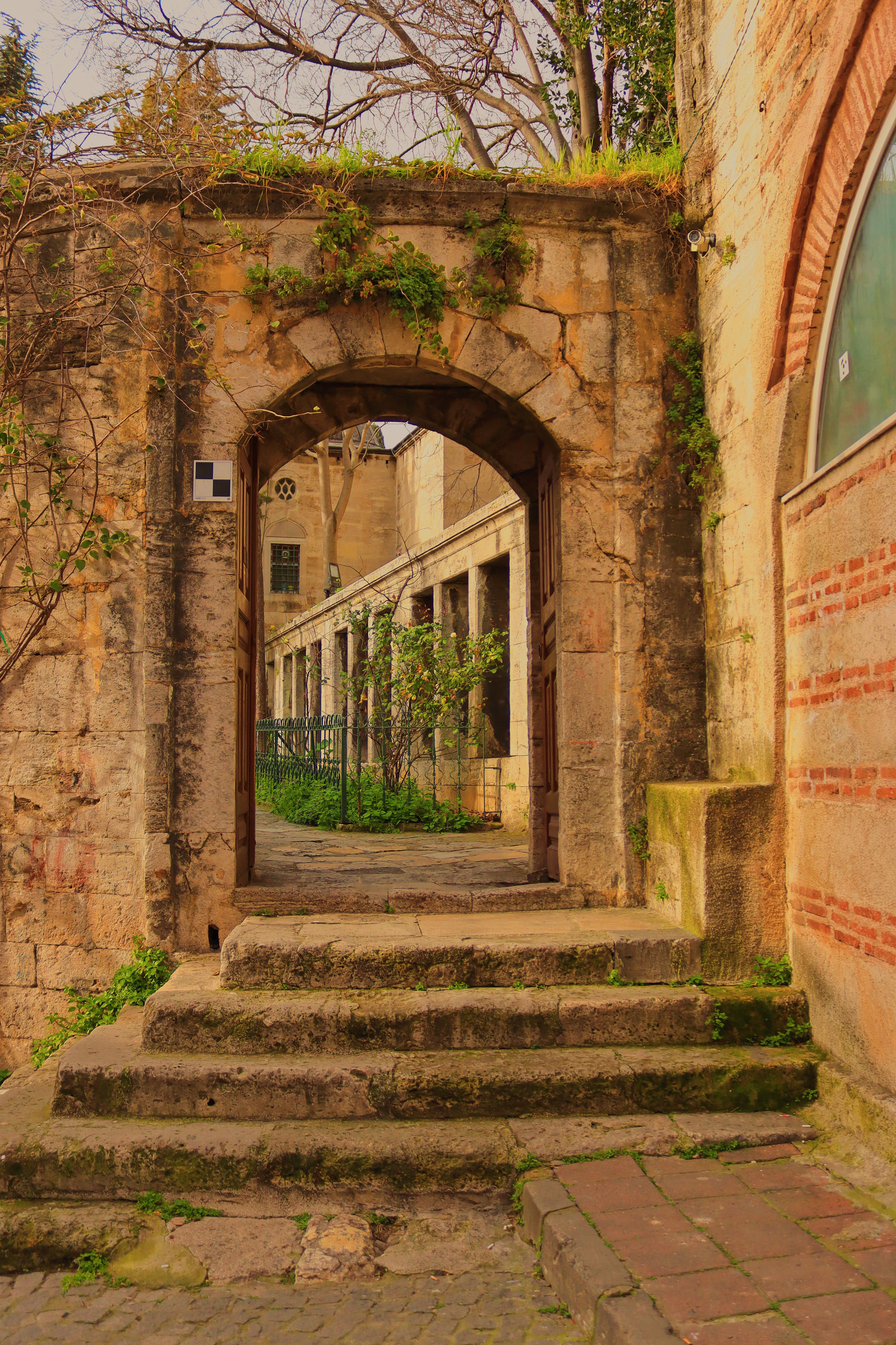An old stone archway leading to a building · Free Stock Photo
