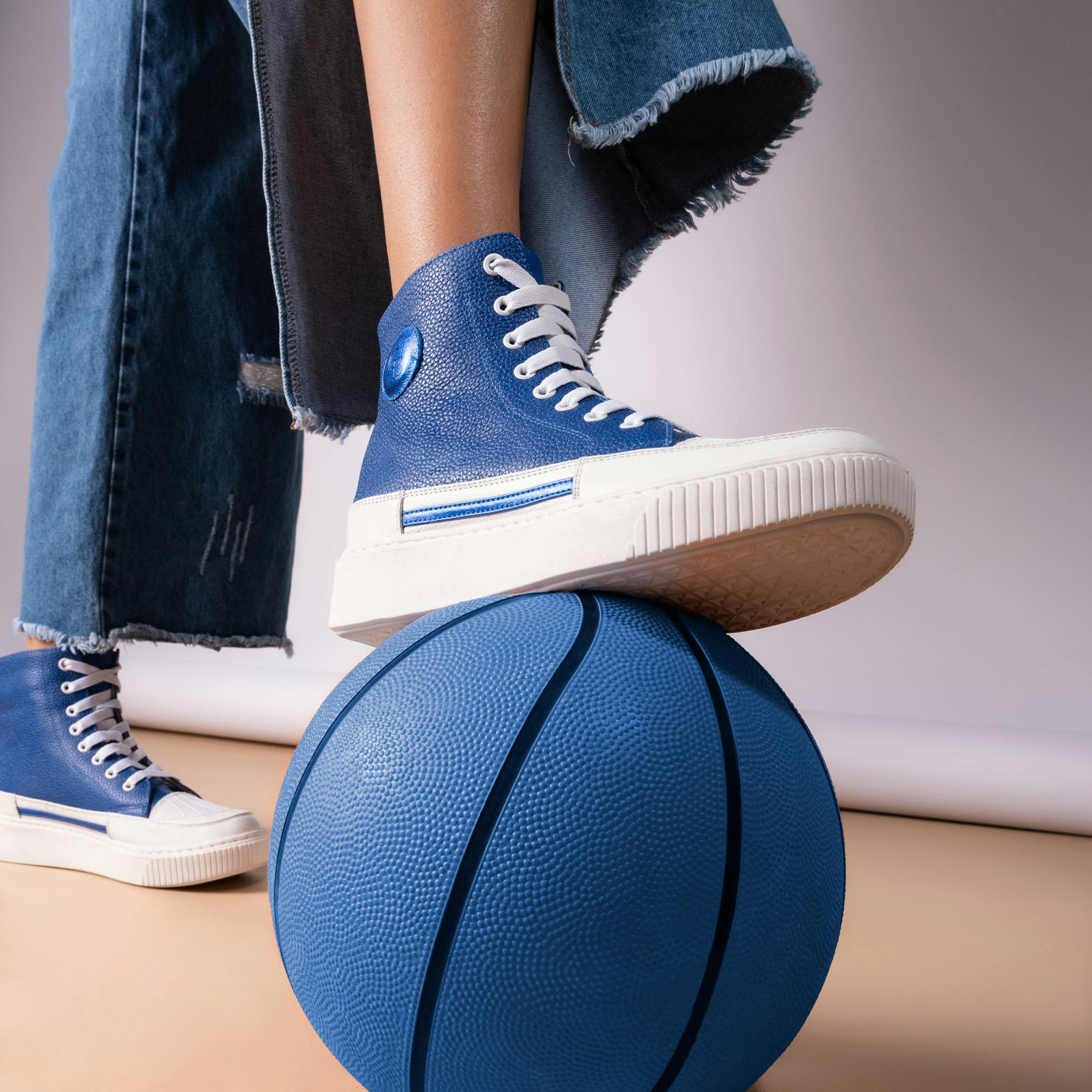 Studio Shot of a Woman Wearing Blue Sneakers · Free Stock Photo