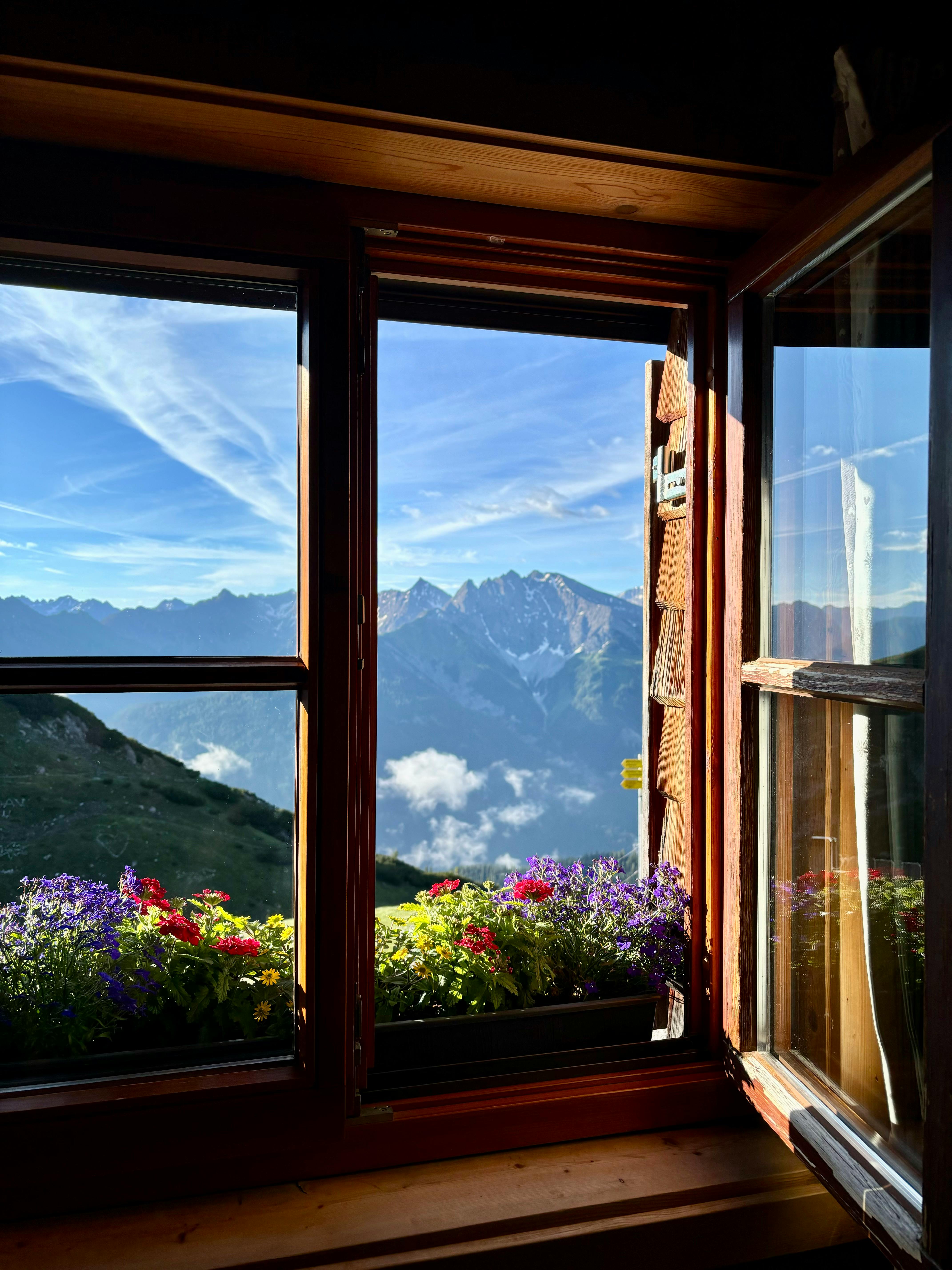 Flowers behind Windows of House in Mountains · Free Stock Photo