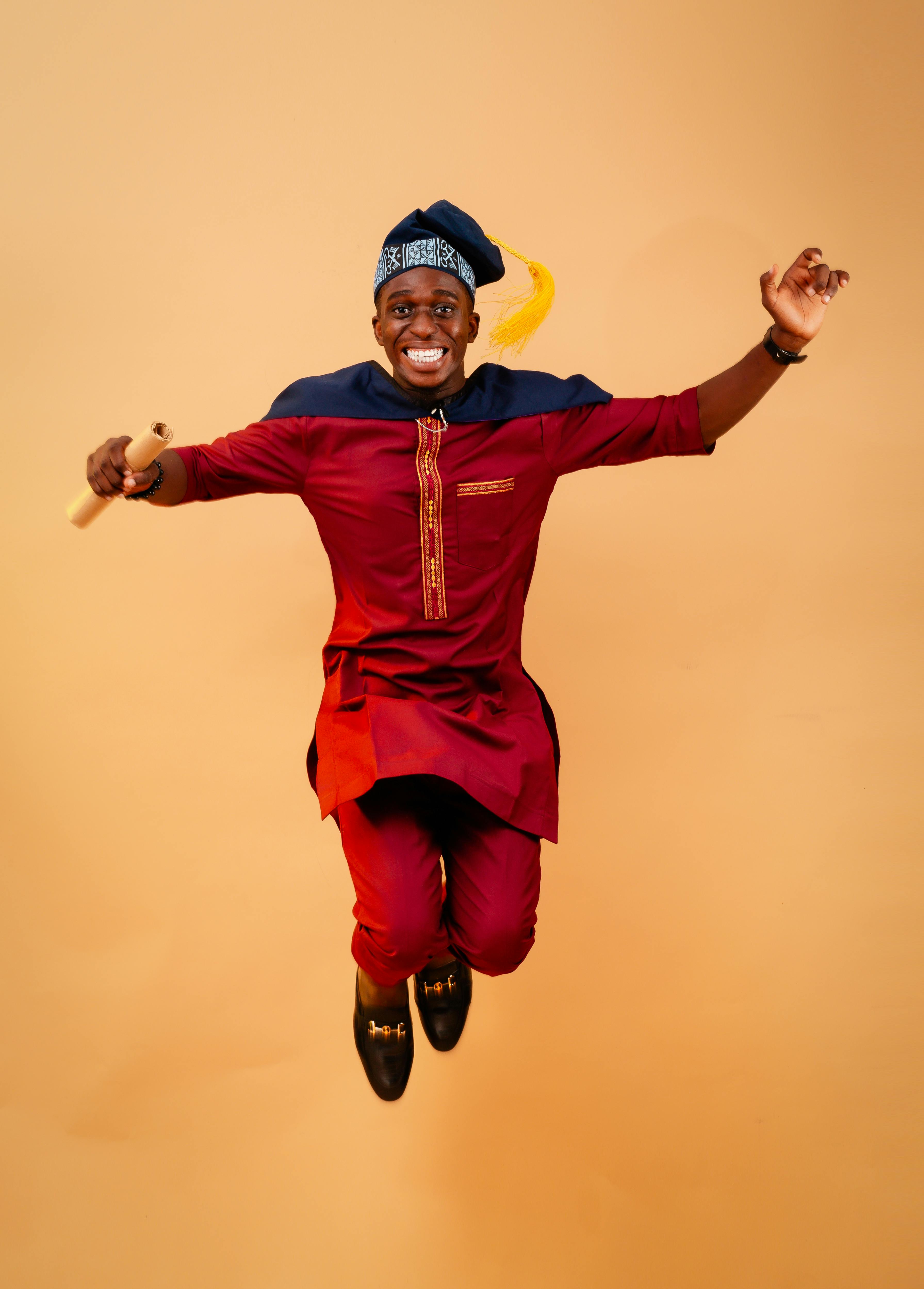 Happy Man in Graduation Cap and Gown Jumping · Free Stock Photo