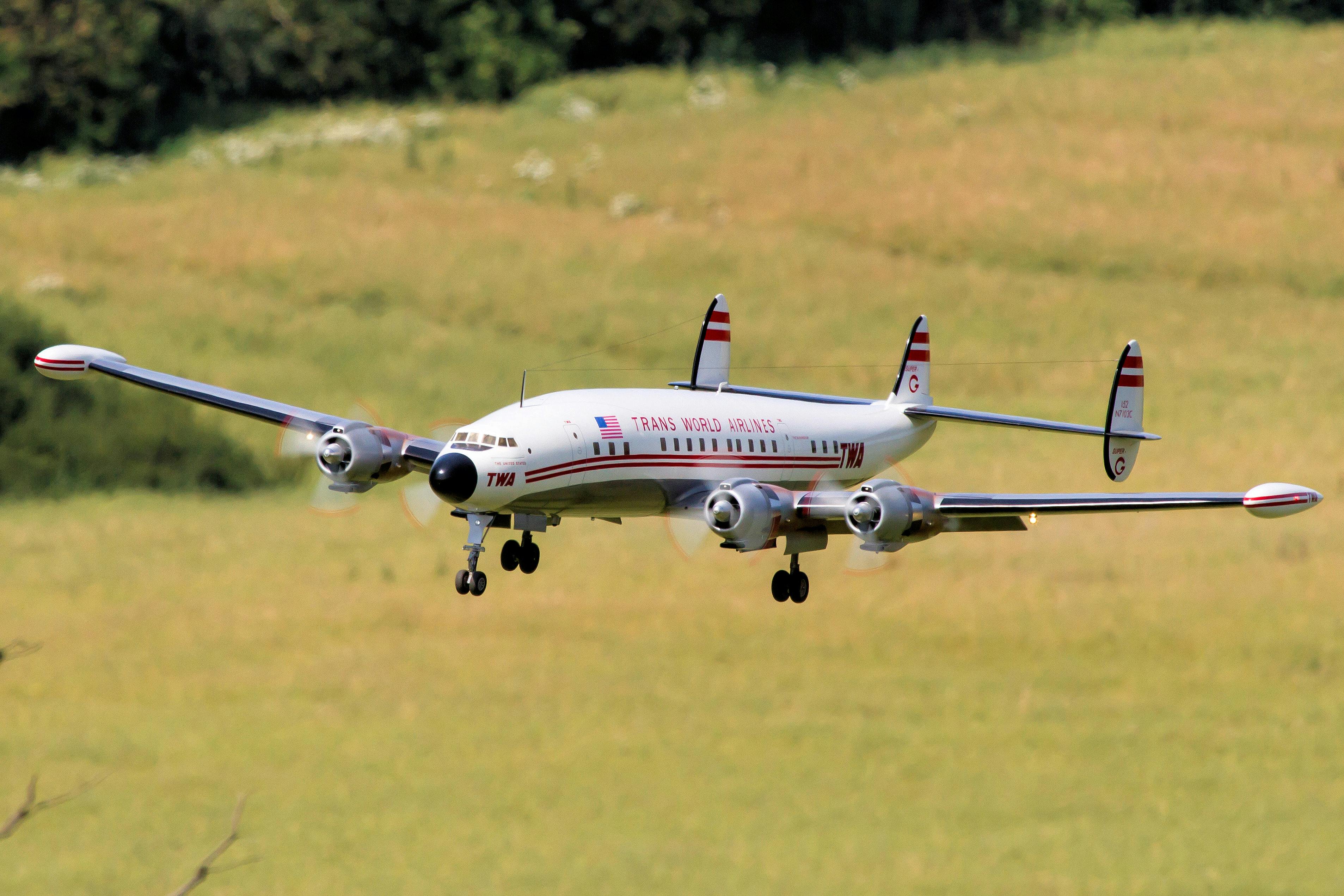 A small airplane flying over a field · Free Stock Photo