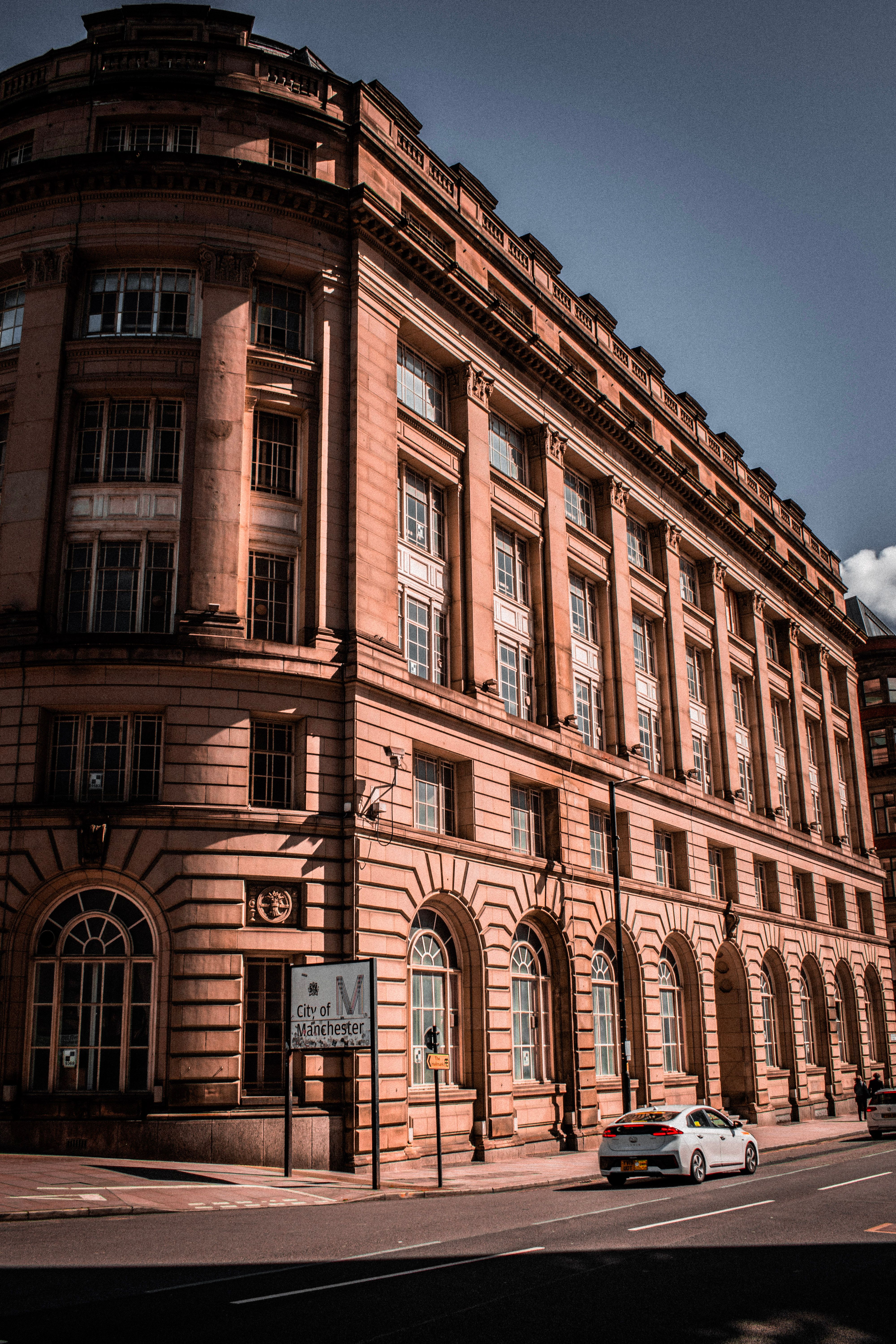 A large building with cars parked in front of it · Free Stock Photo