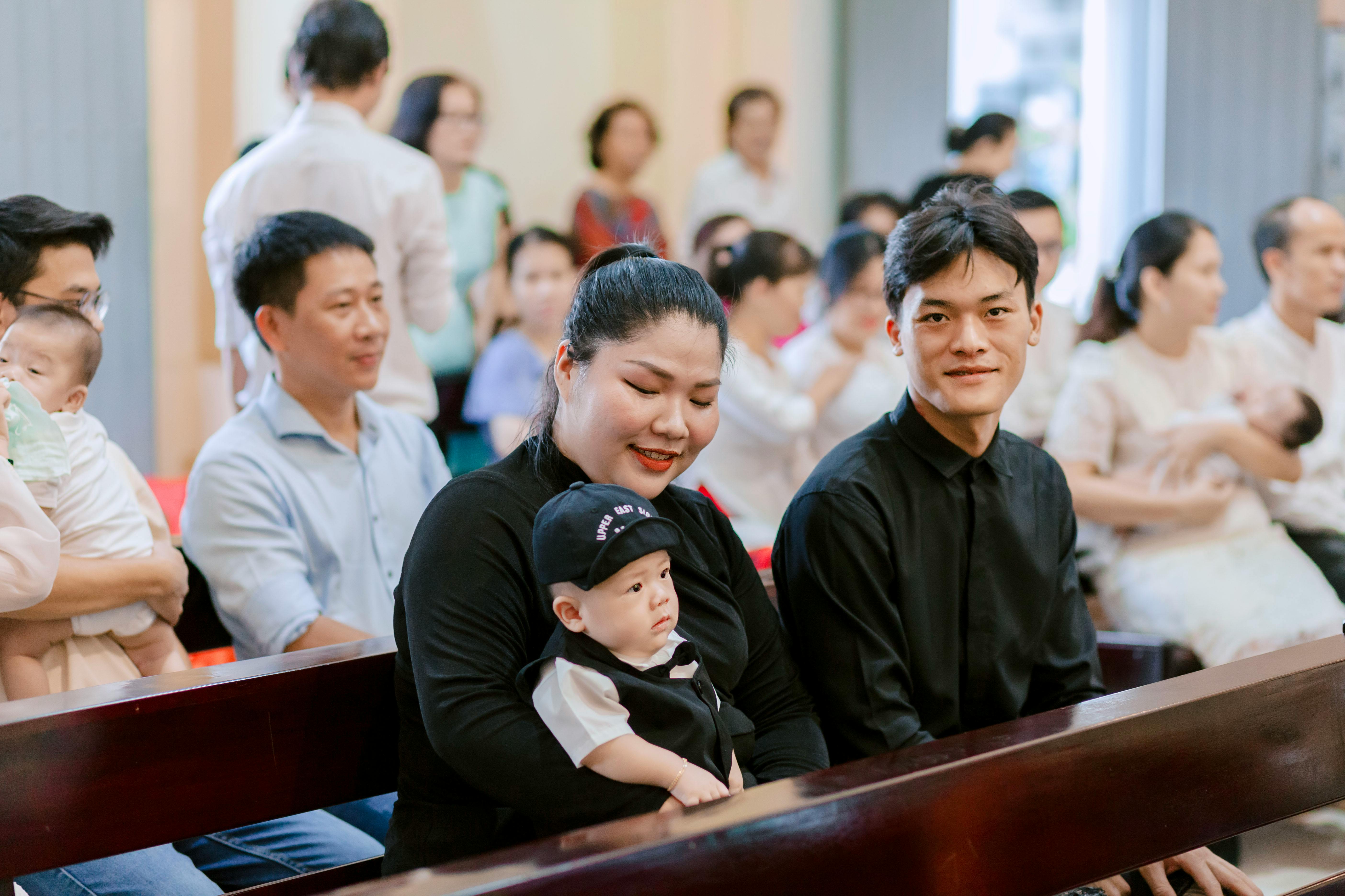 A family is sitting in a church pew · Free Stock Photo