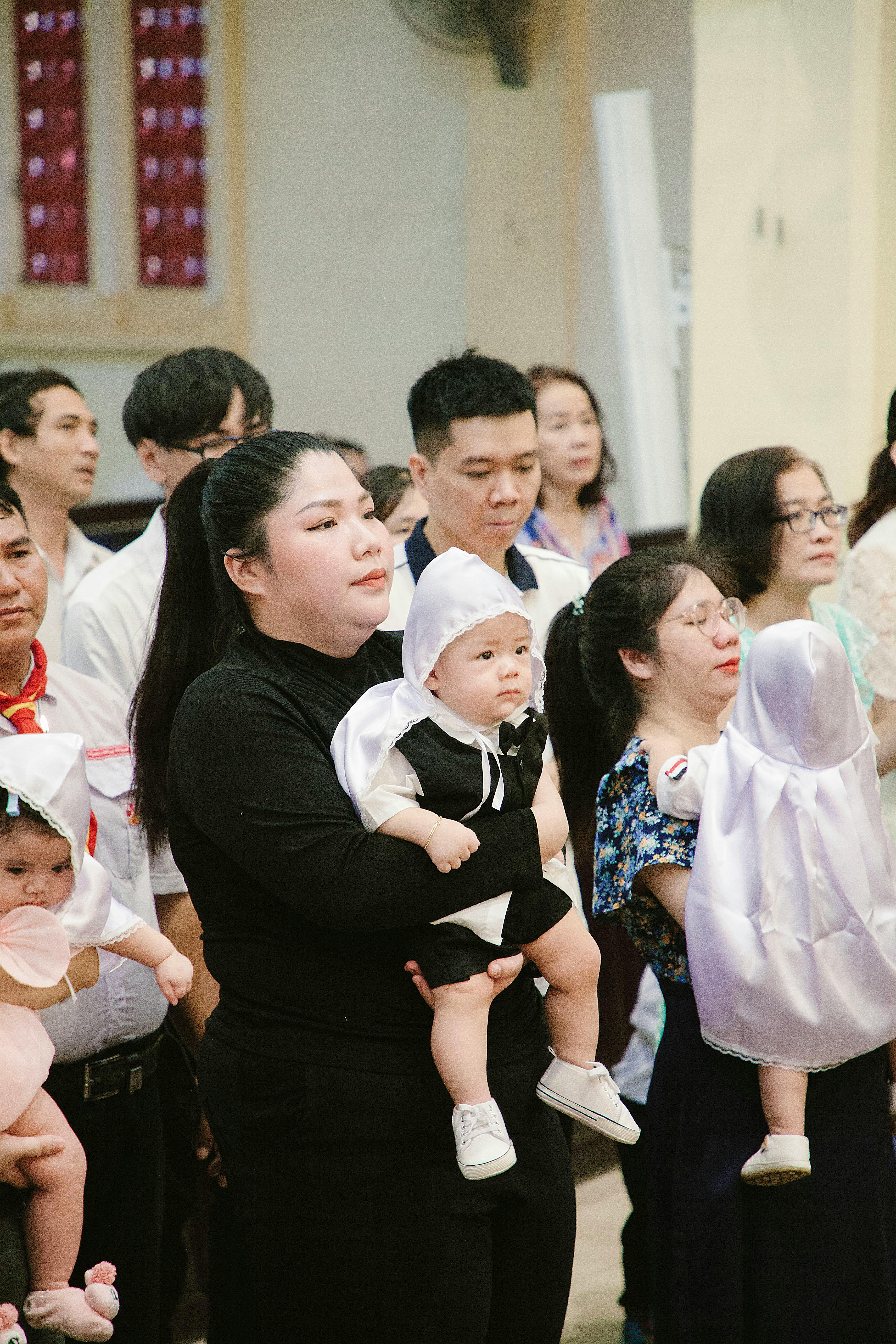 Mother Standing and Holding Baby in Ceremony · Free Stock Photo