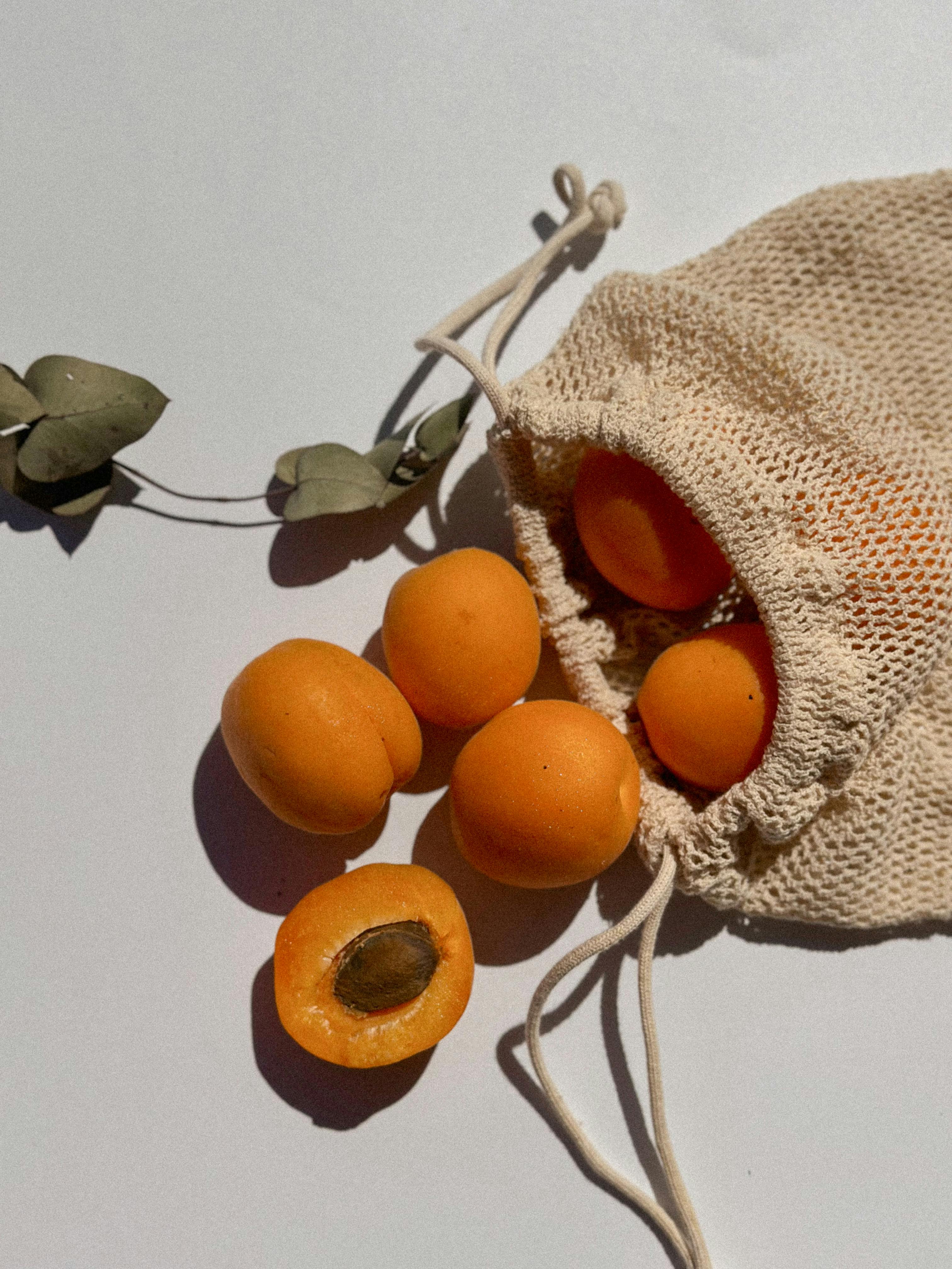 Apricots Falling out of String Bag · Free Stock Photo