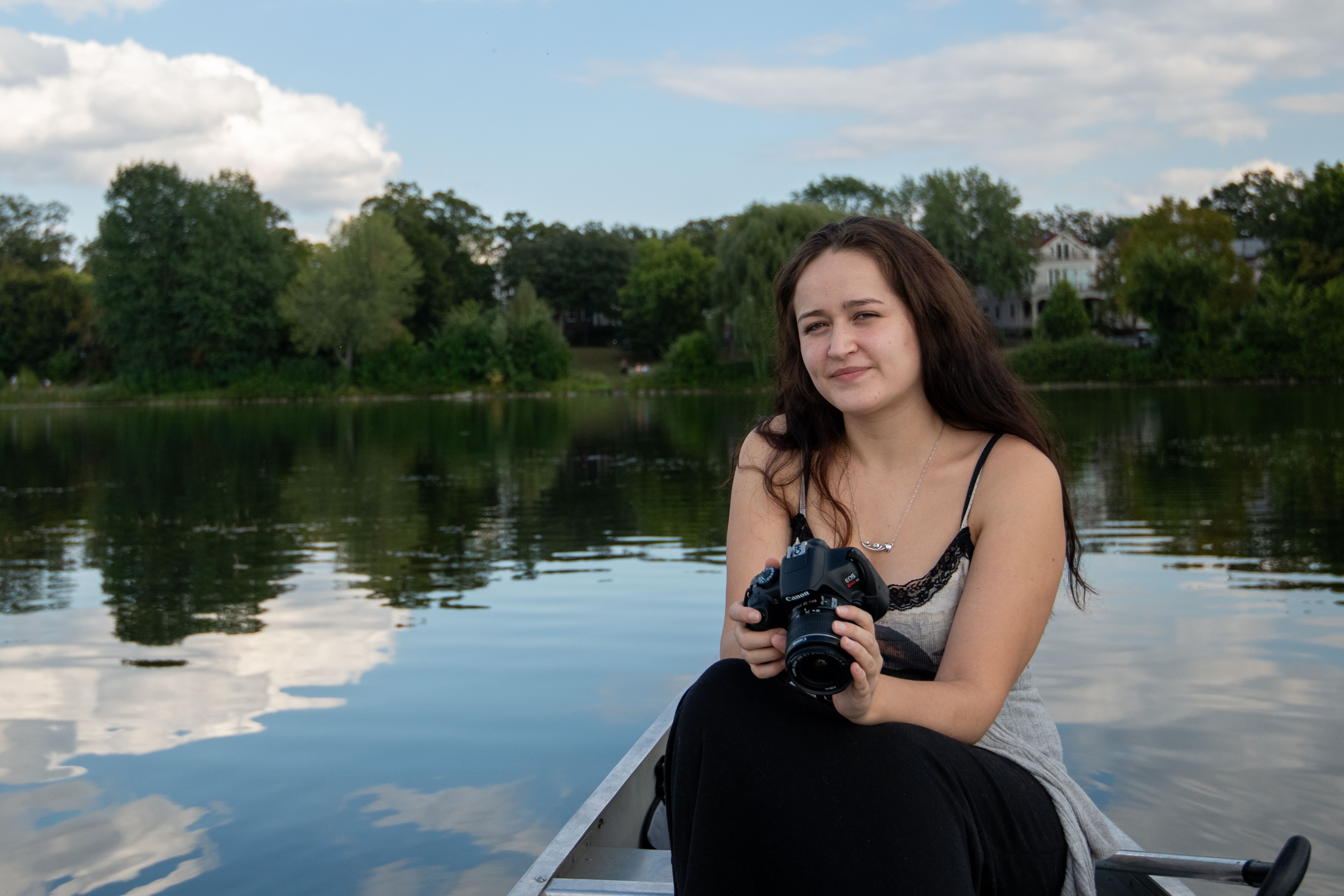 Portrait of a Young Woman Sitting in a Canoe with a Camera in Hands ...