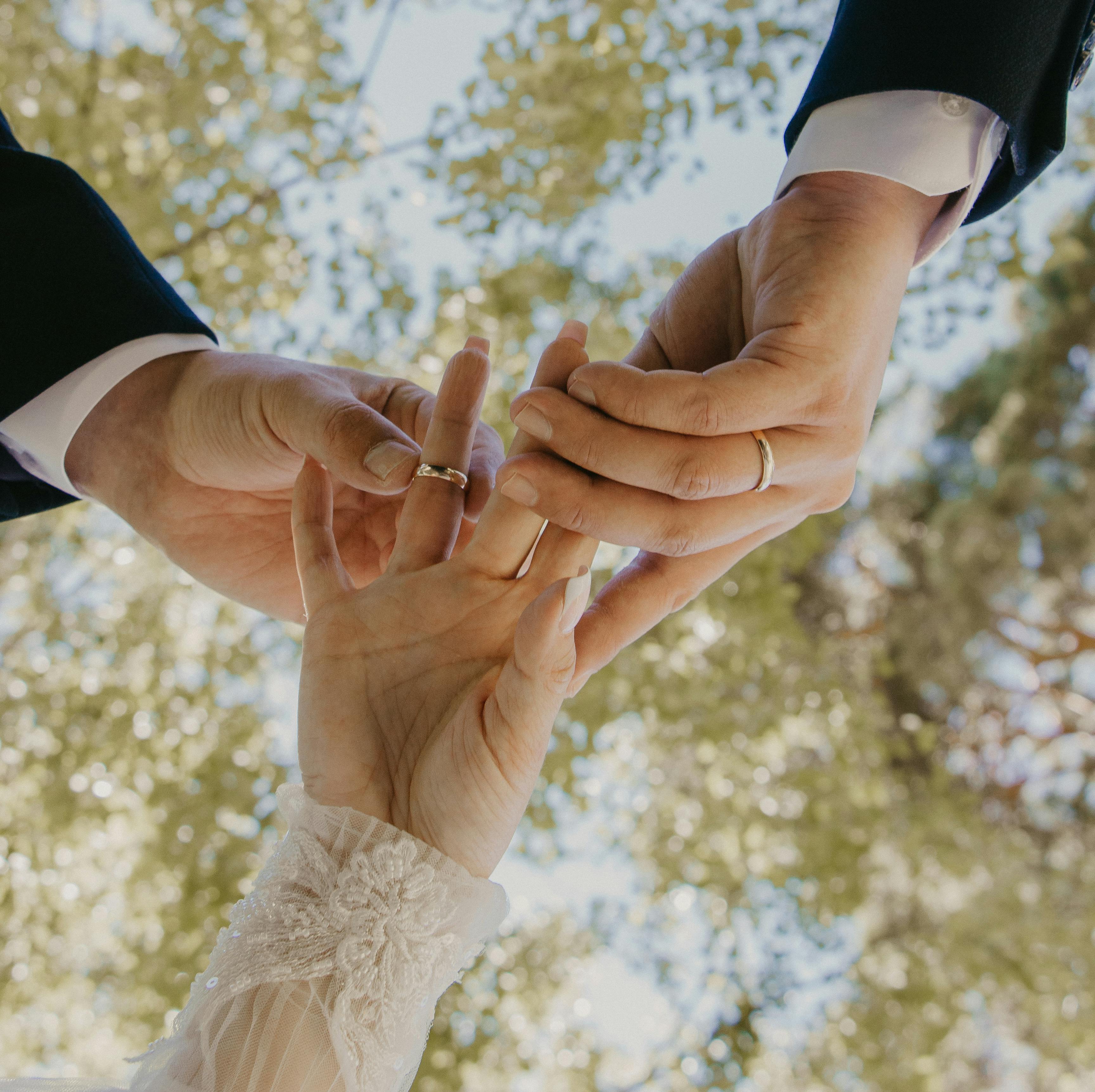 A couple putting their wedding rings on each other · Free Stock Photo