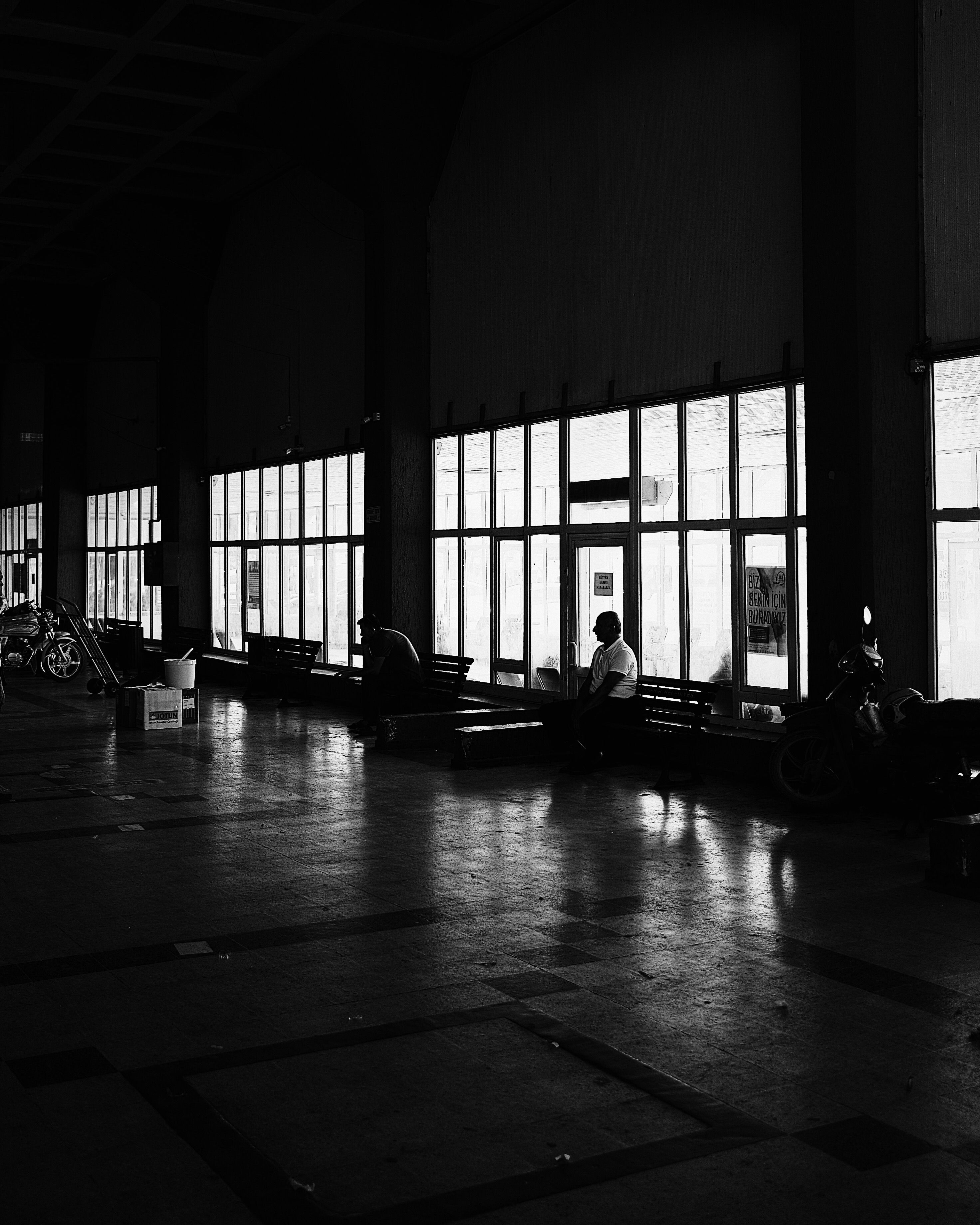 Men Sitting on Benches Along Windows in Terminal · Free Stock Photo