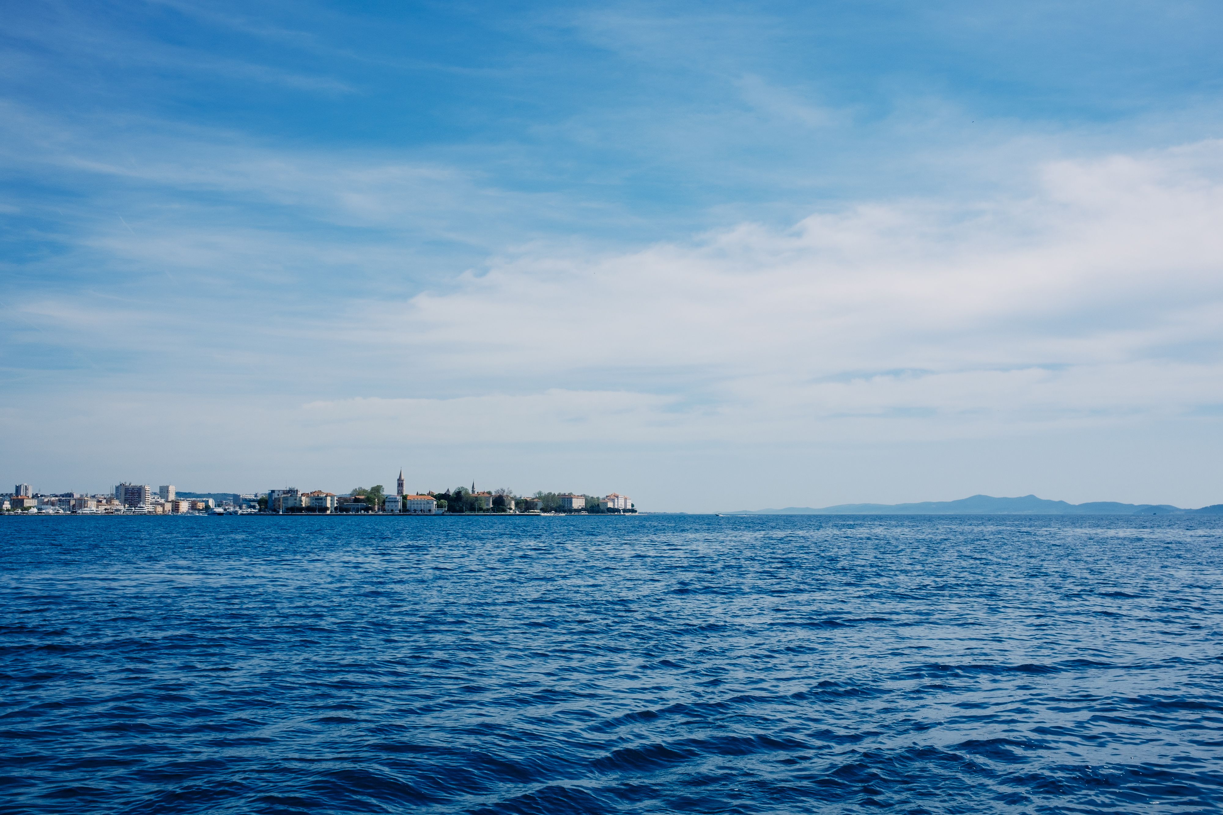 A view of the ocean with a small island in the distance · Free Stock Photo