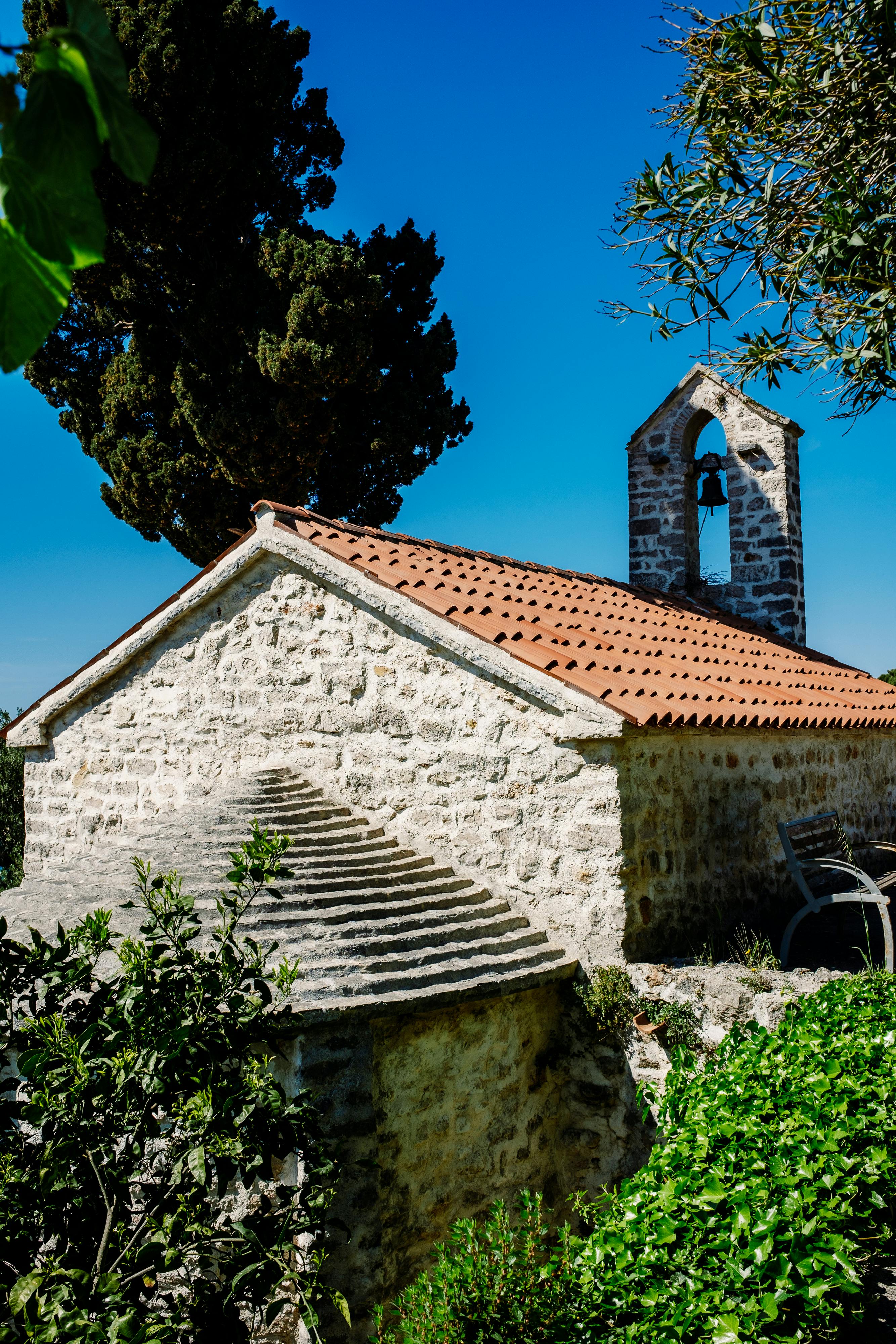 A small stone church with a bell tower · Free Stock Photo