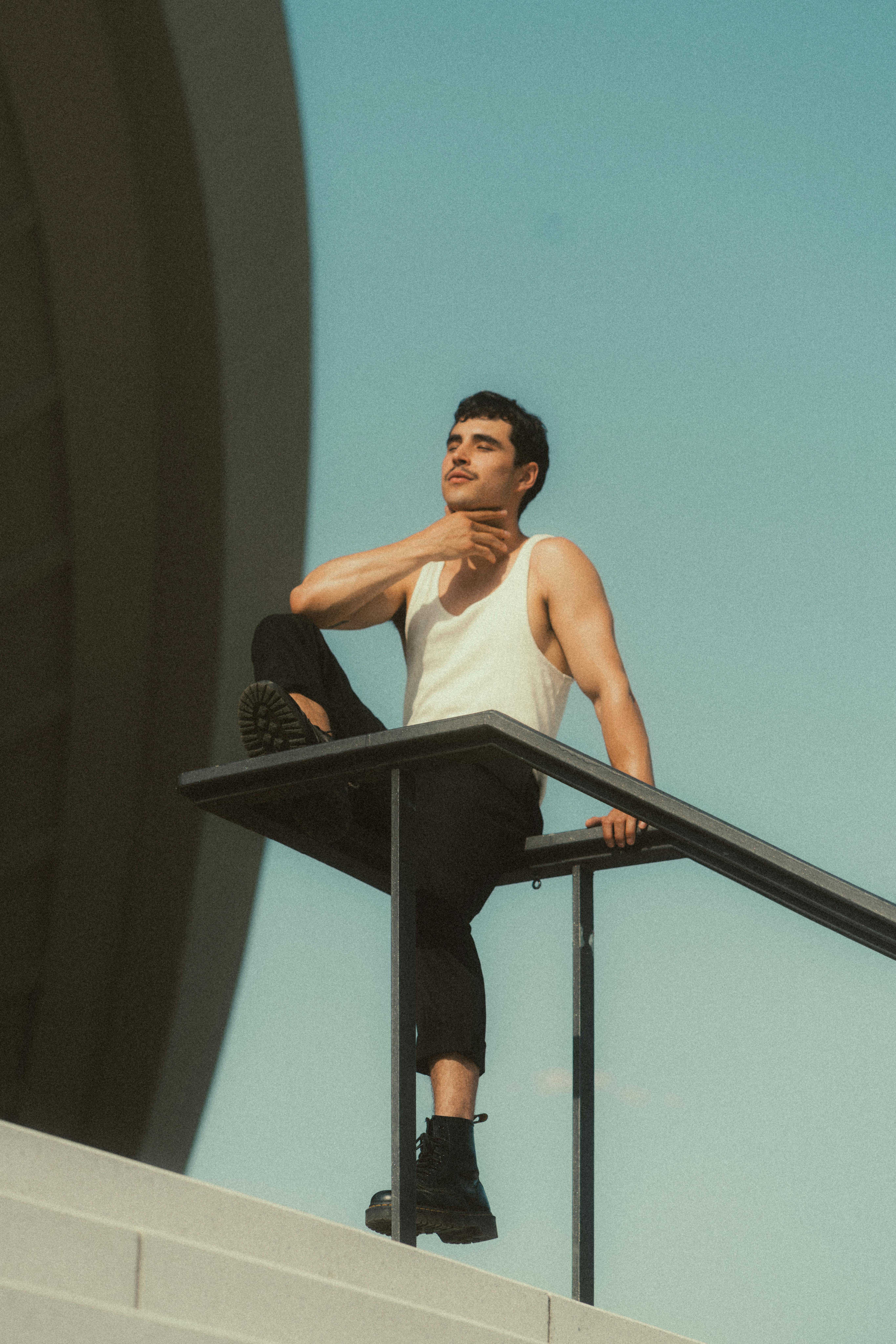 A Fashionable Man Sitting on the Handrail · Free Stock Photo