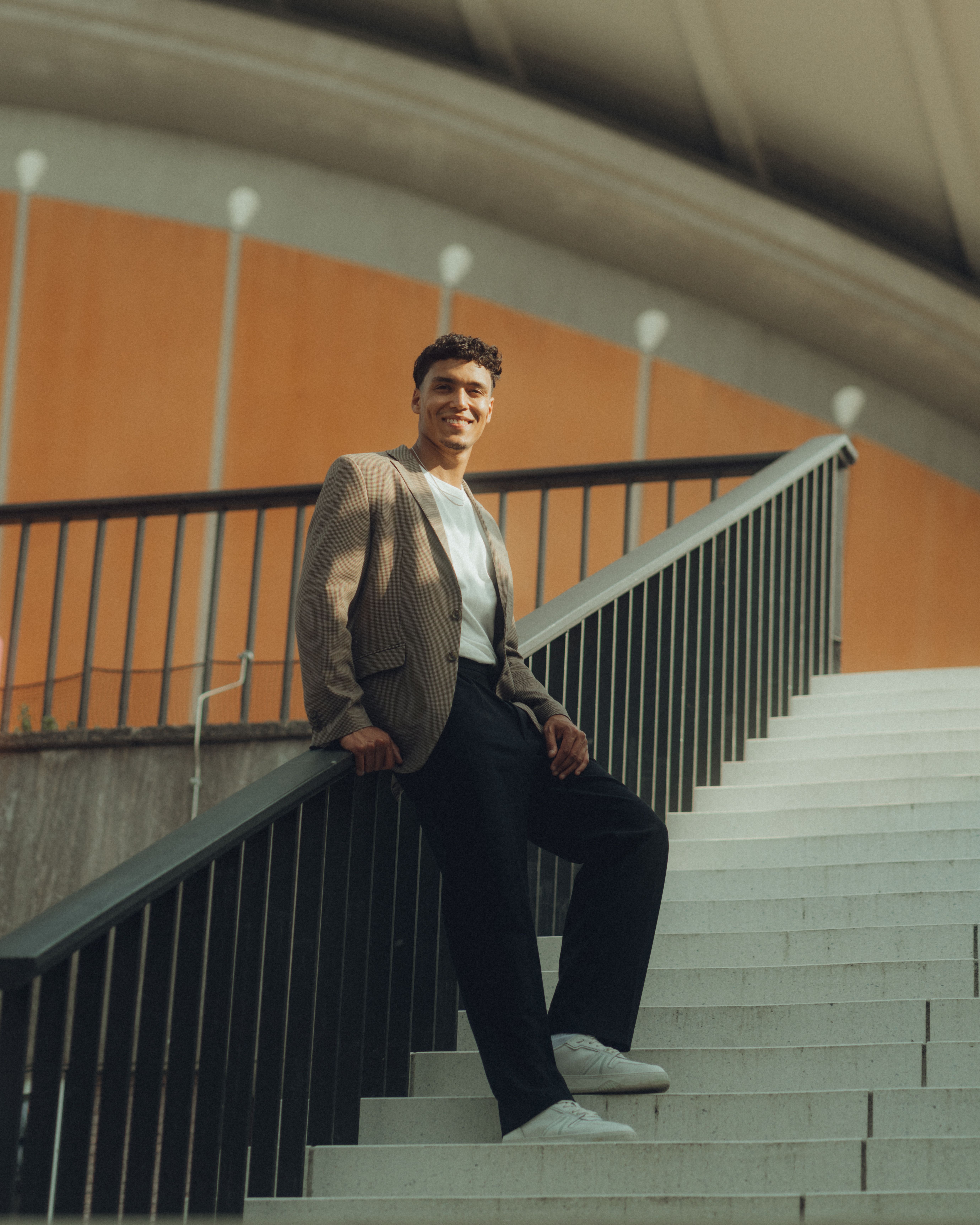 A Fashionable Man Standing on the Stairs · Free Stock Photo
