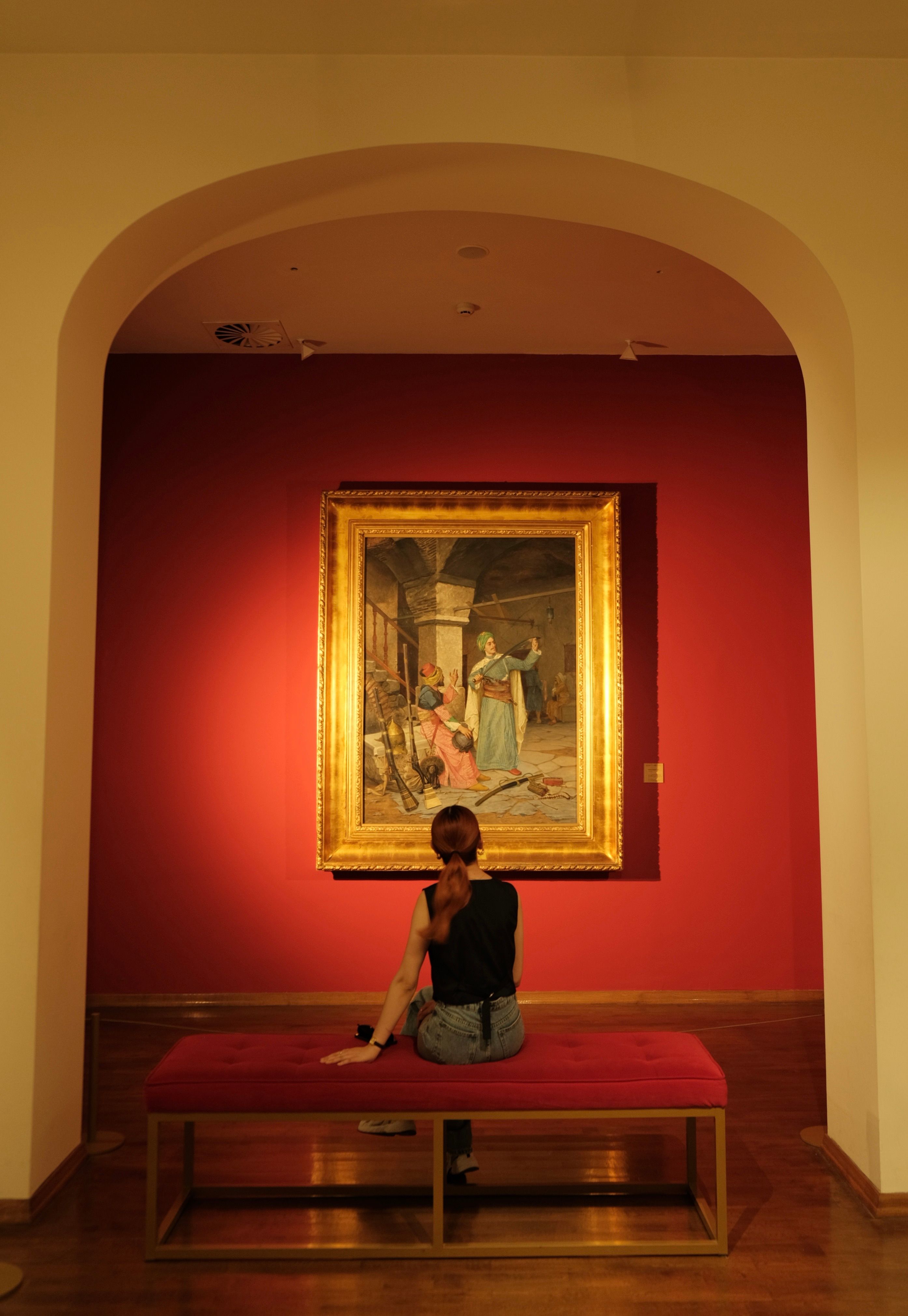Mujer Sentada Frente A Un Cuadro En Un Museo · Foto de stock gratuita