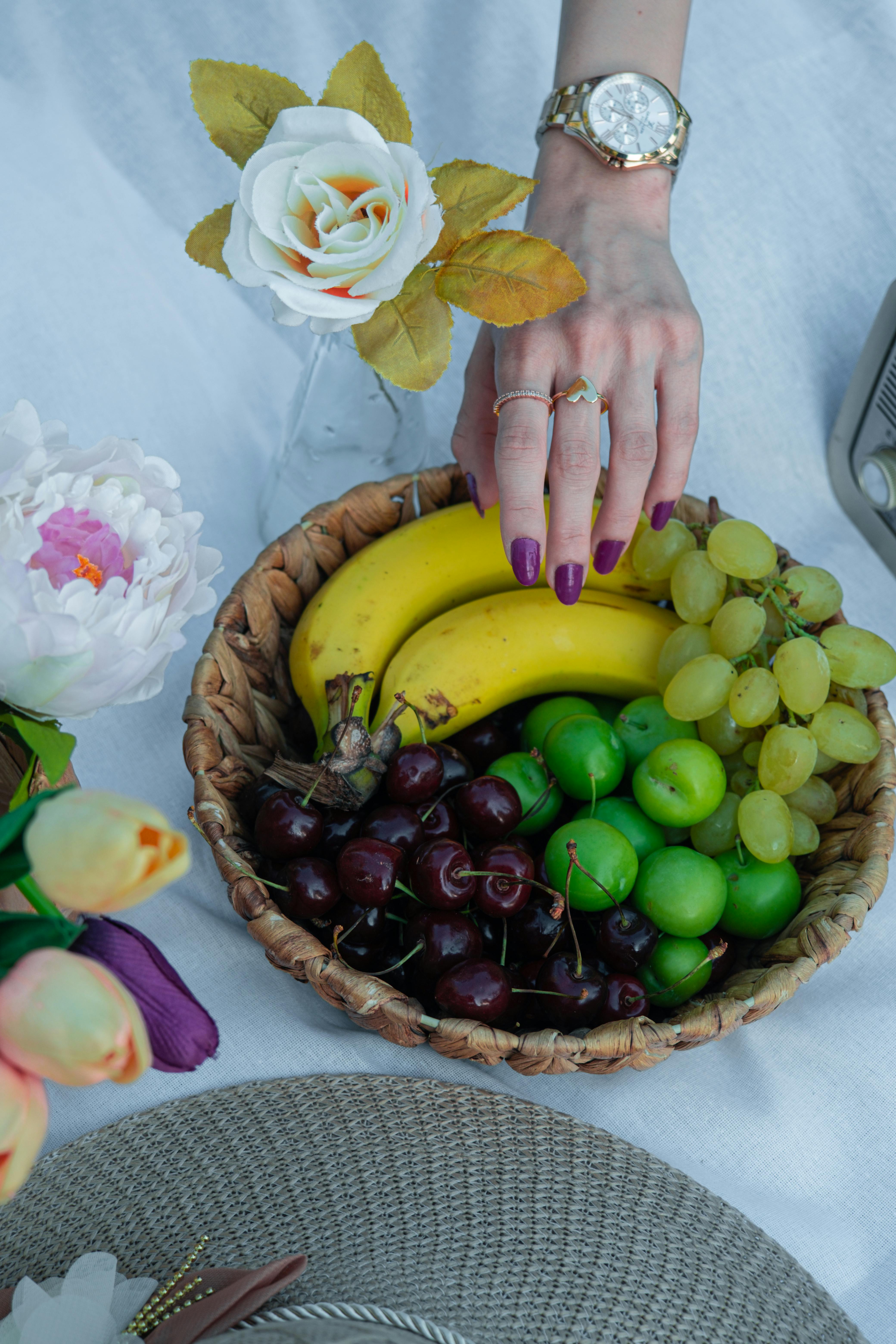 Reaching for a Fruit from the Picnic Basket · Free Stock Photo