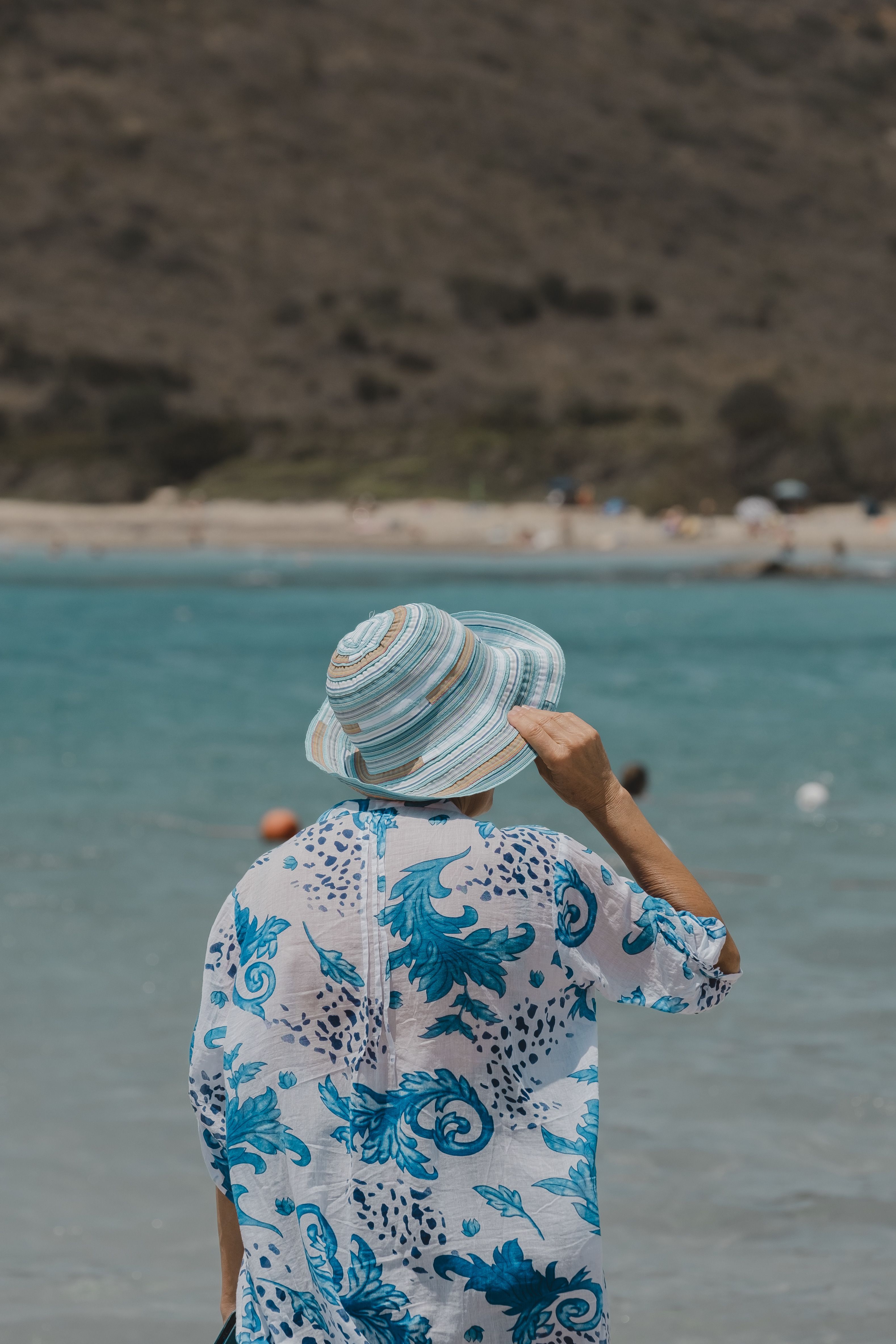 Person in Hat and Shirt on Sea Shore · Free Stock Photo