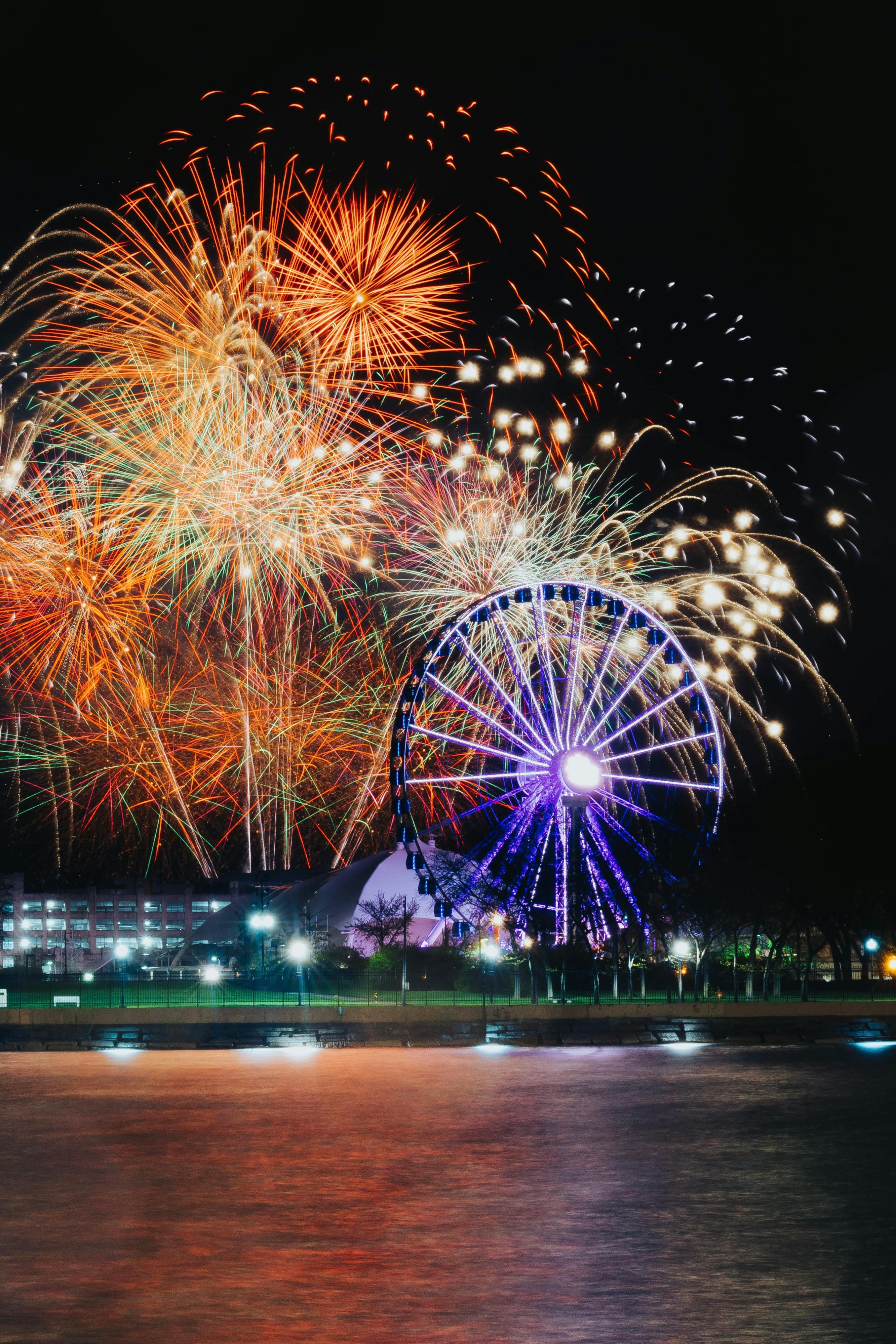View of the Illuminated Ferris Wheel and Fireworks over the Navy Pier ...