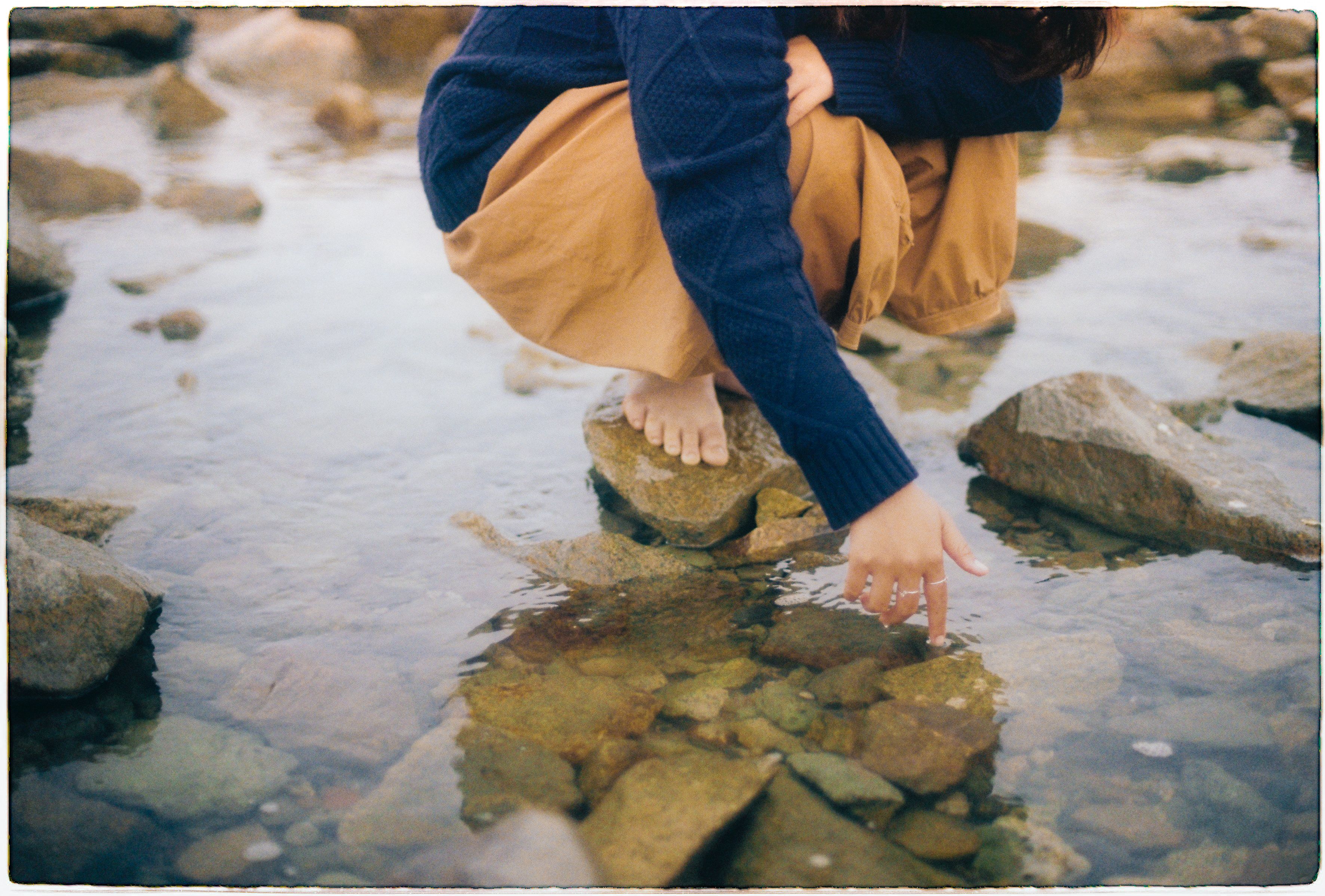 Child Squatting and Playing in Water · Free Stock Photo