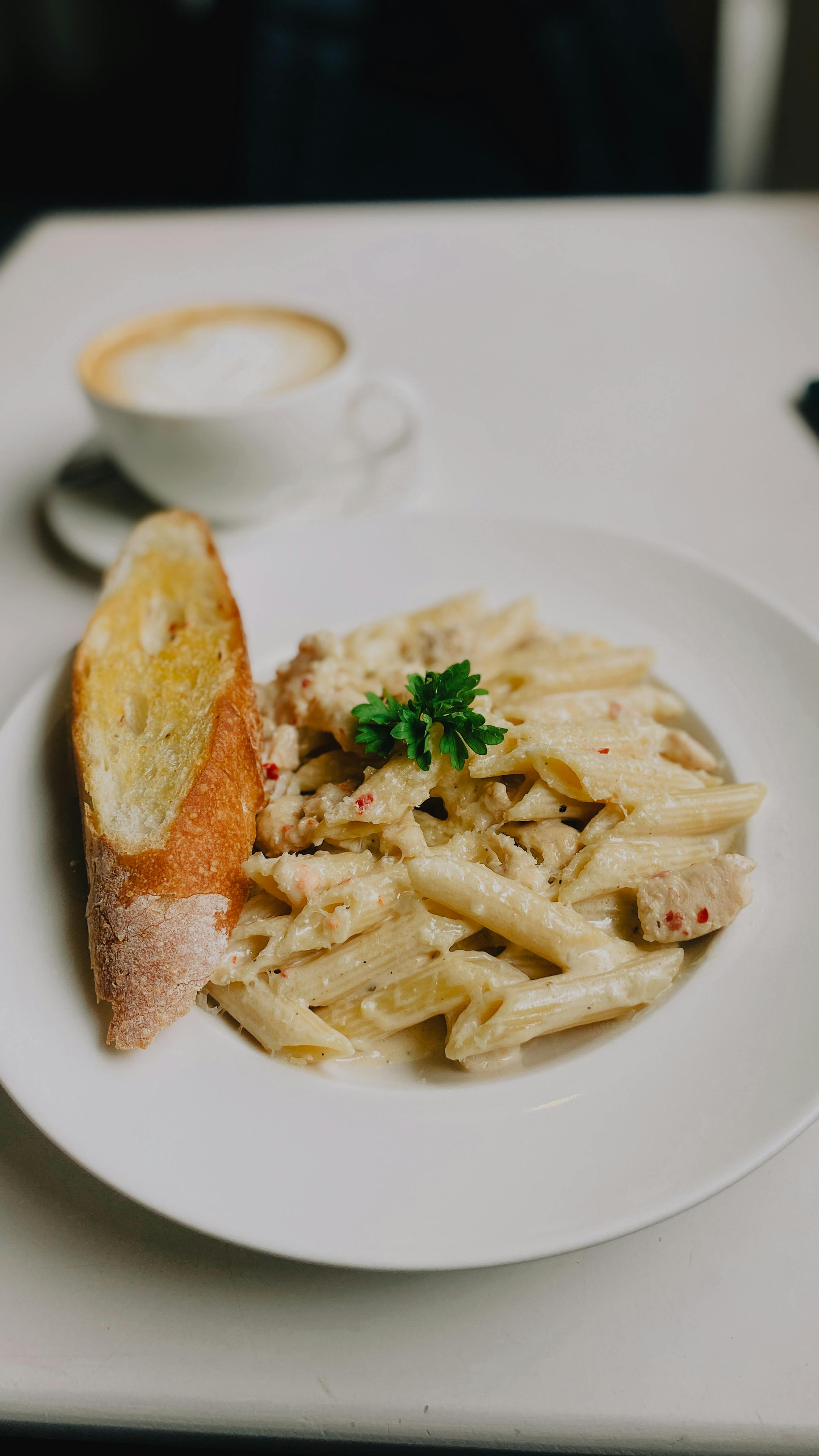 Pasta and Bread Served in a Restaurant · Free Stock Photo