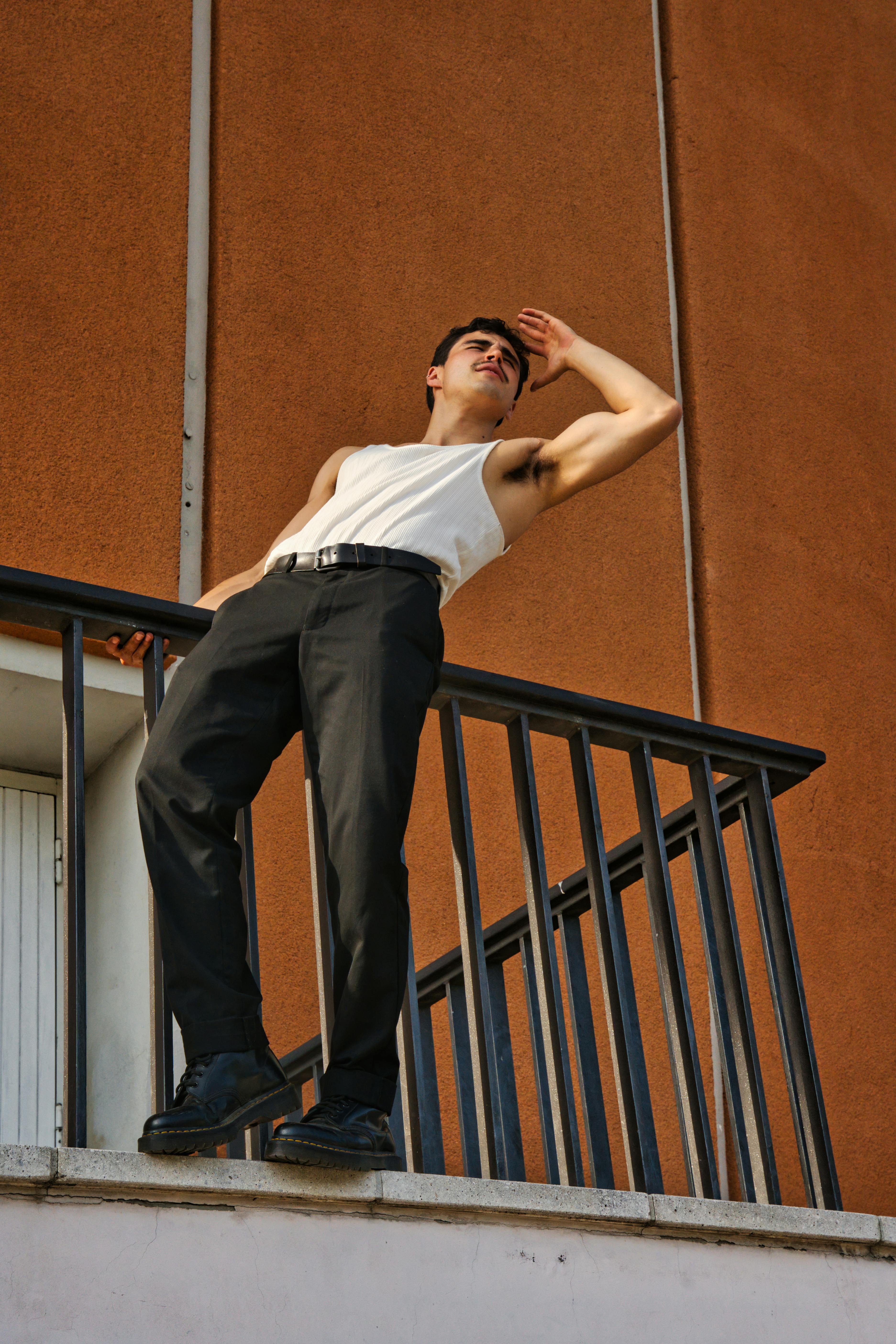Man Leaning on Balcony Railing · Free Stock Photo