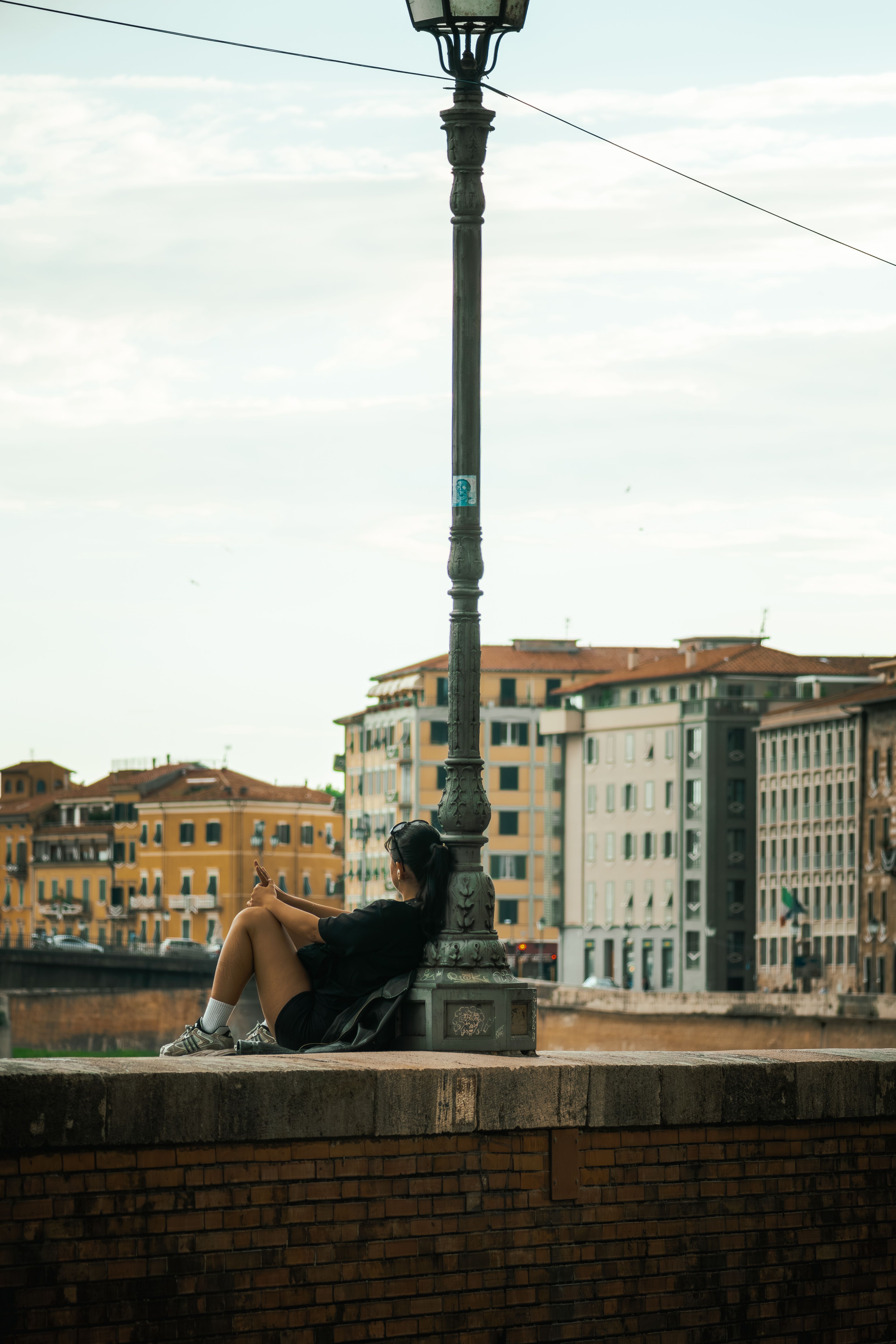 A person sitting on a bench under a lamp post · Free Stock Photo