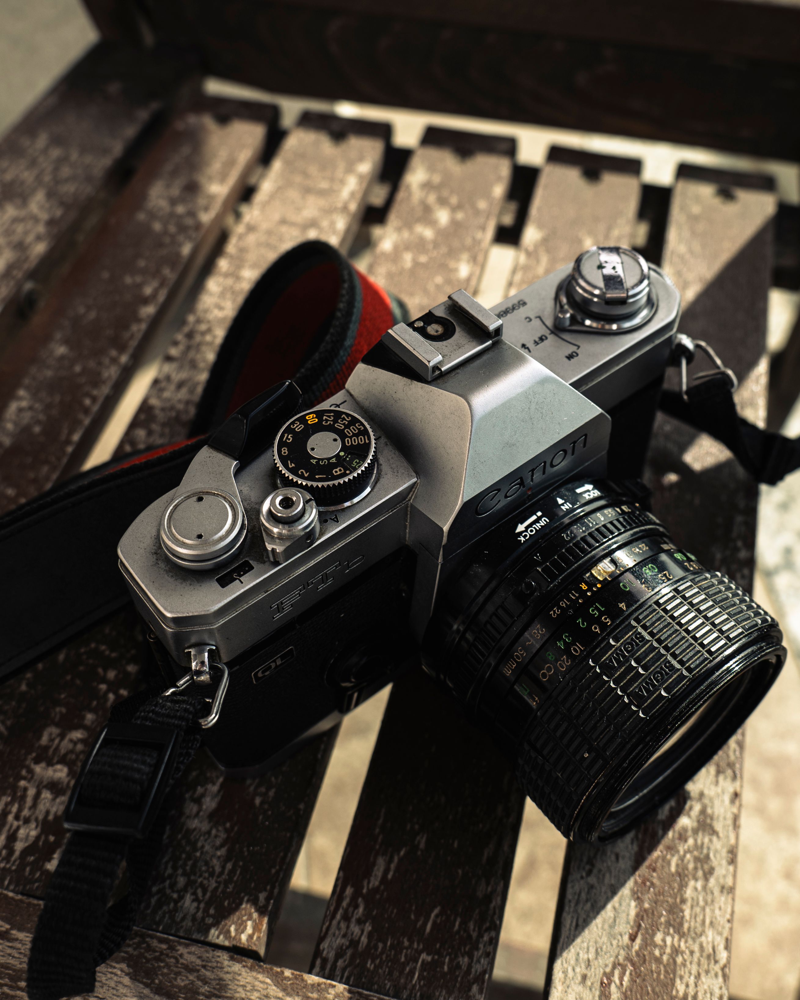 A camera sitting on a wooden bench · Free Stock Photo